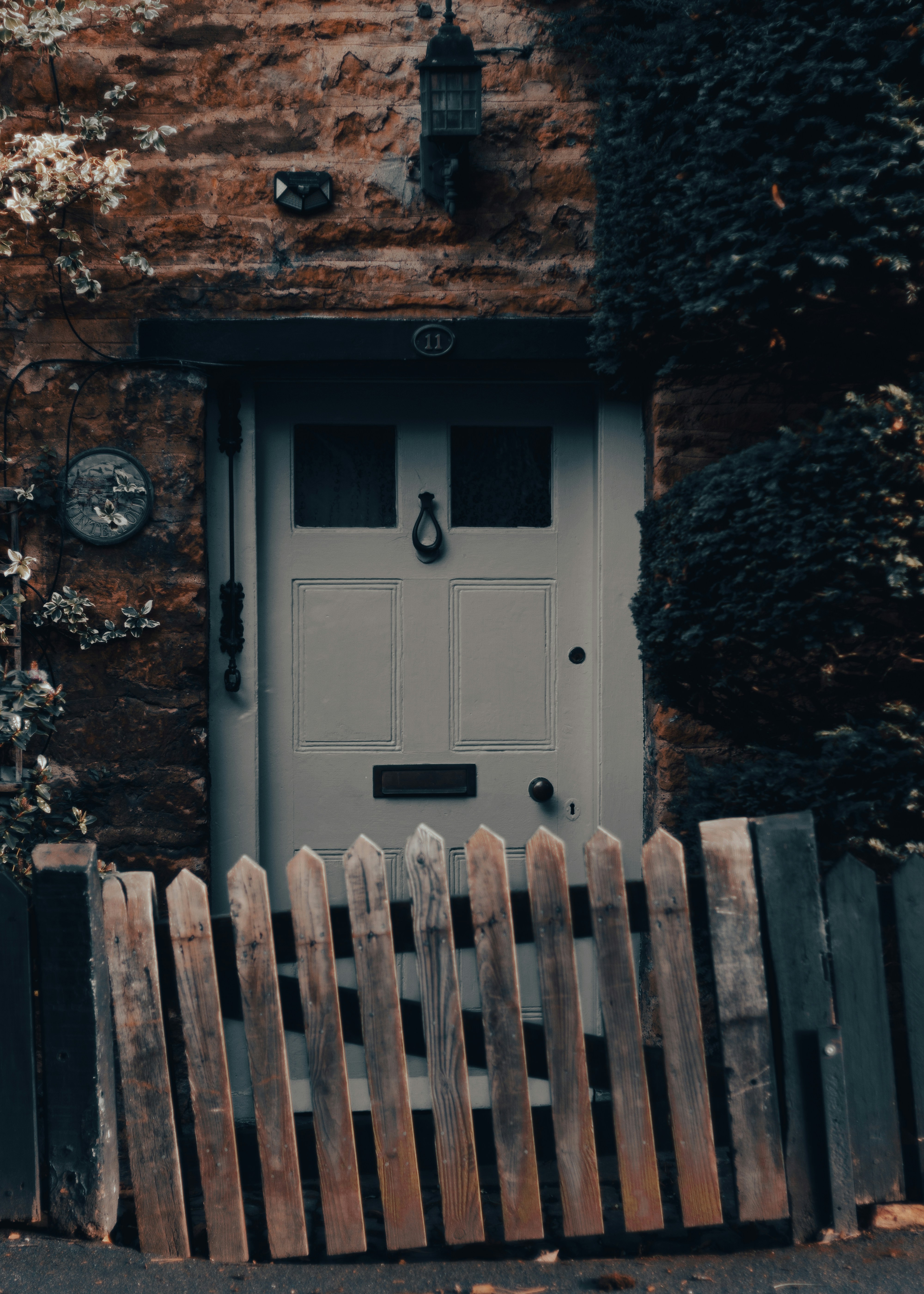 Twilight Entry: A Weathered Cottage Door Behind a Leaning Picket Fence