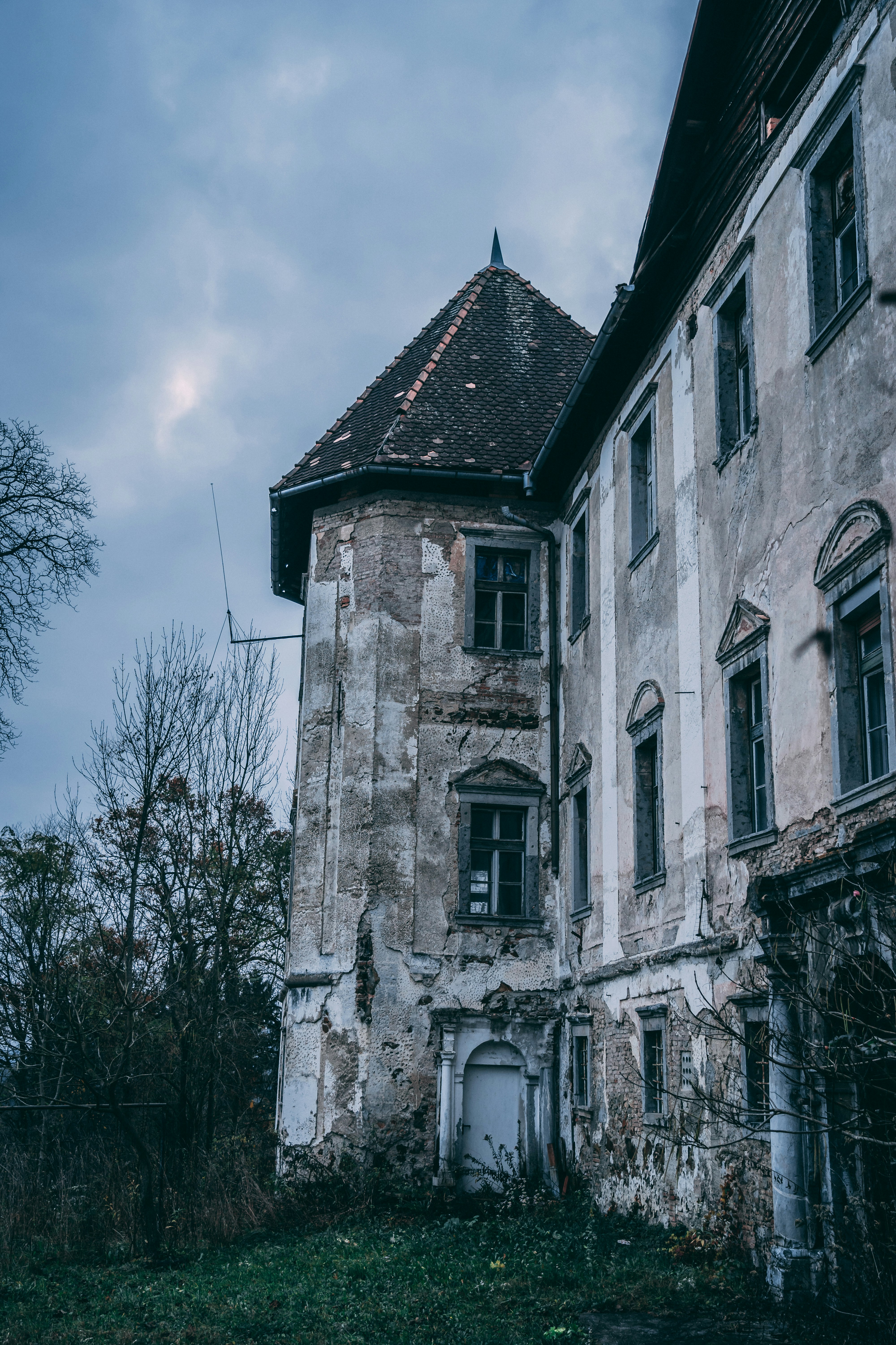 Weathered Manor: Crumbling Facade Against a Murky Sky