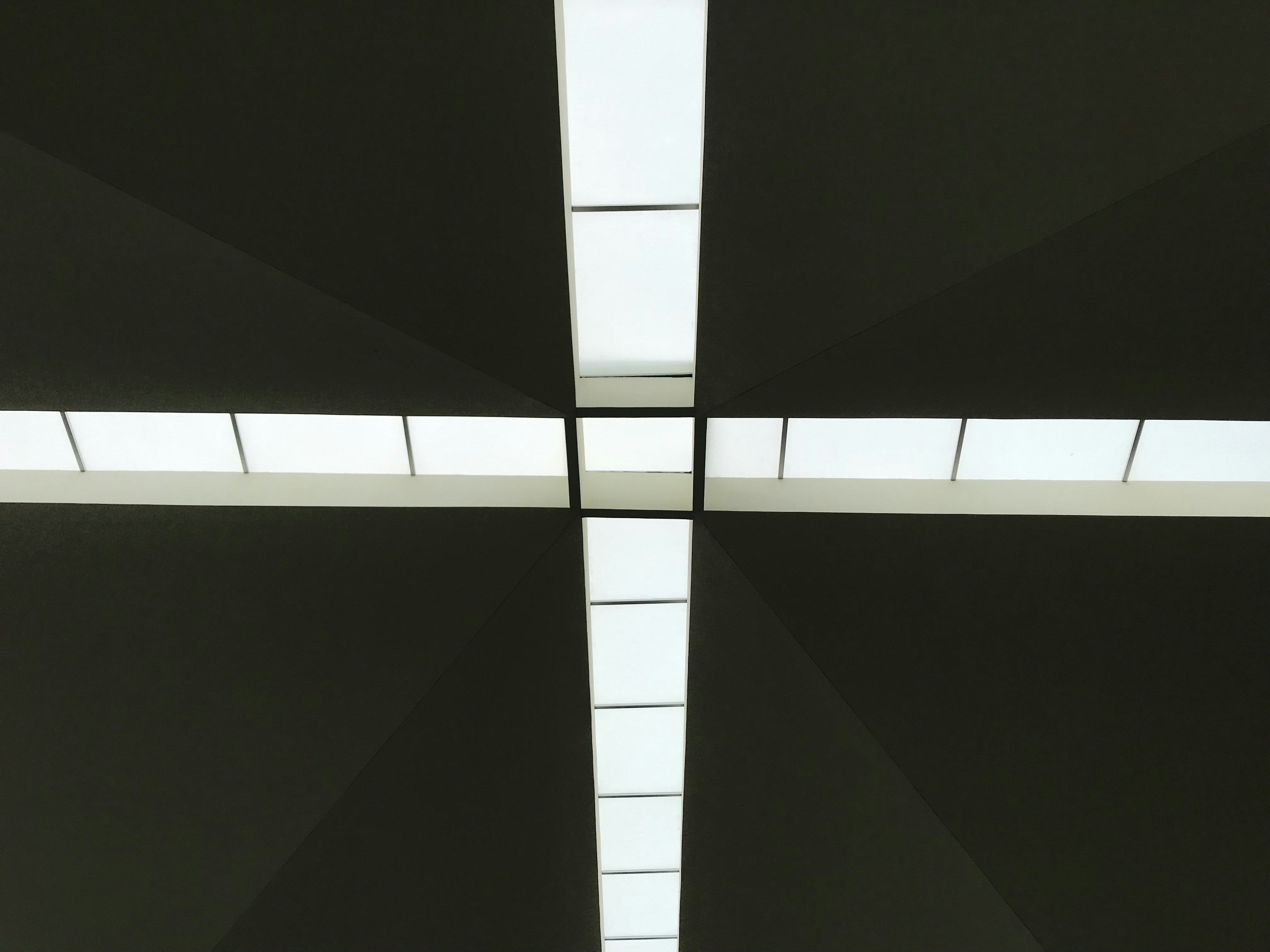 Geometric ceiling design featuring illuminated panels converging at the center, creating a striking visual symmetry.