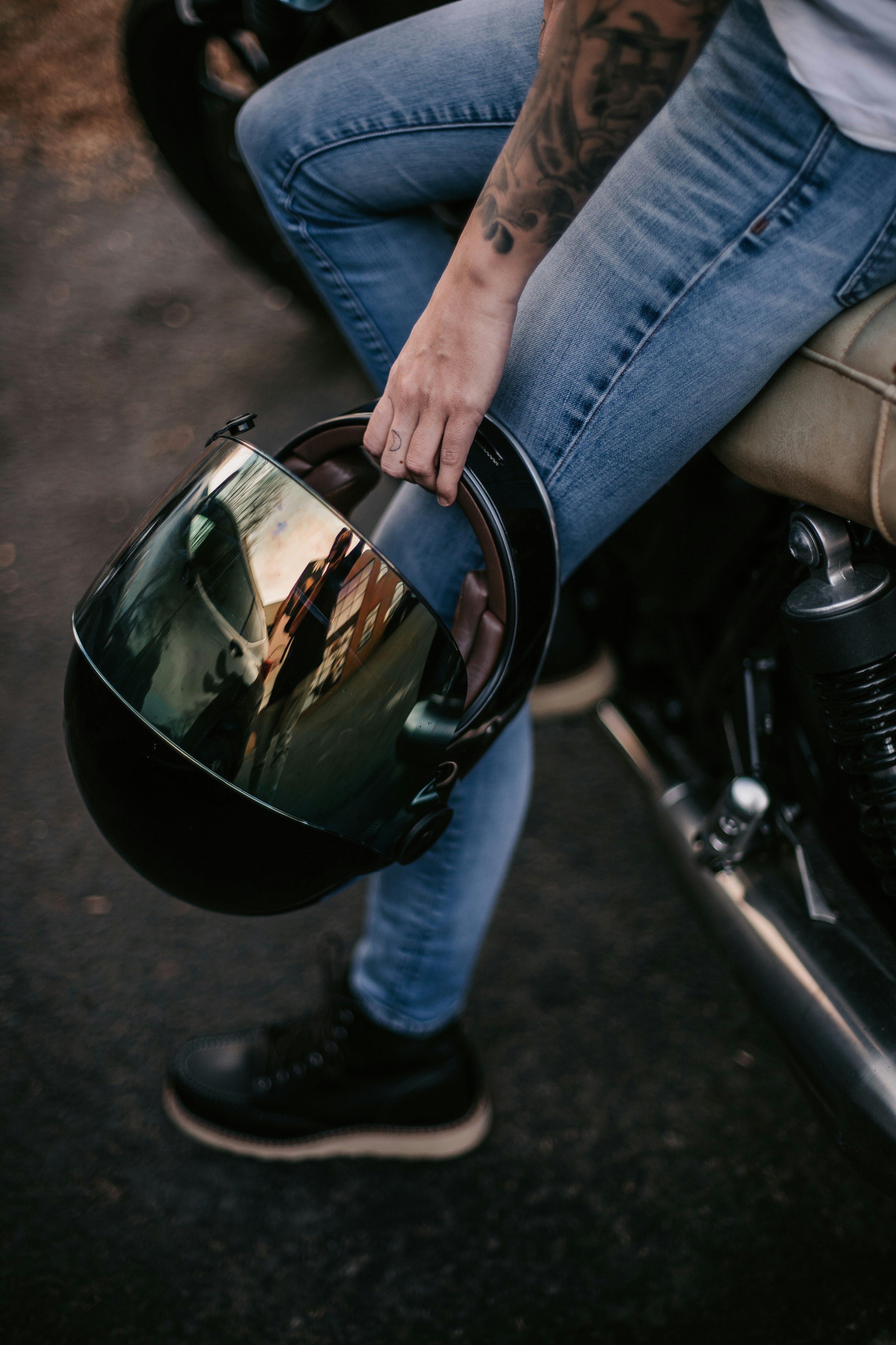 Denim, Tattoo, and Chrome: Grasping a Reflective Motorcycle Helmet