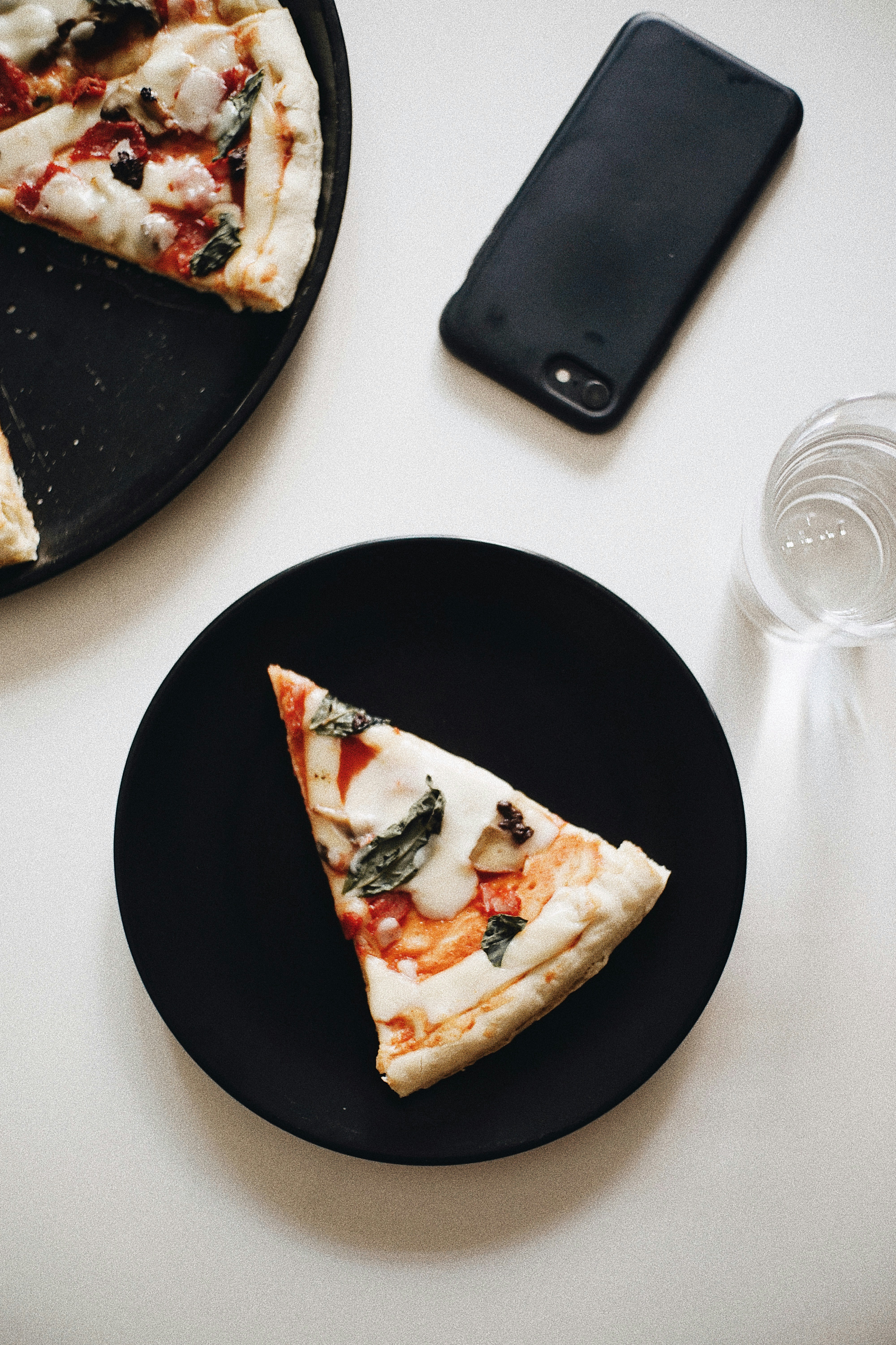 two slices of pizza on a black plate