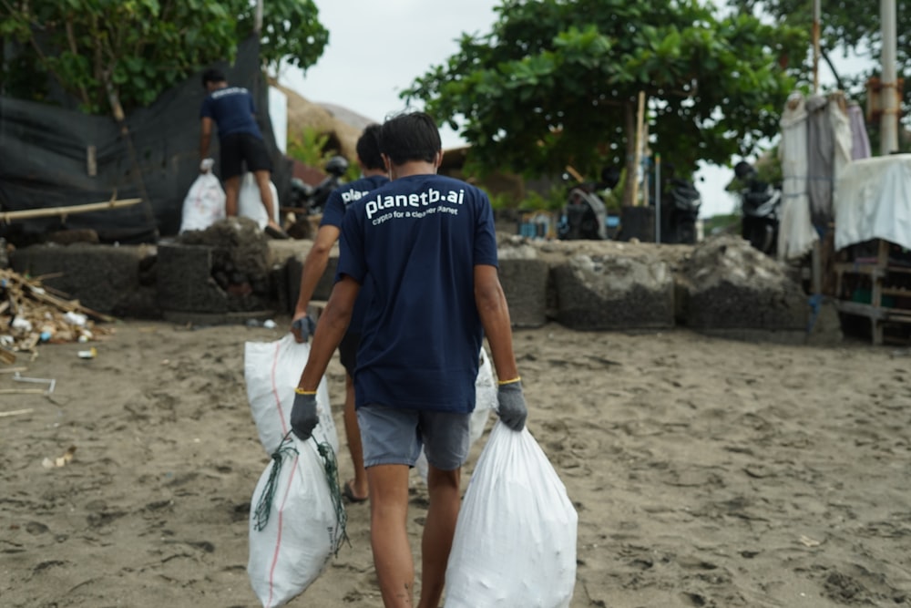 Foto Un hombre cargando dos bolsas de basura en una playa – Imagen El ... Foto Un hombre cargando dos bolsas de basura en una playa – Imagen El ...