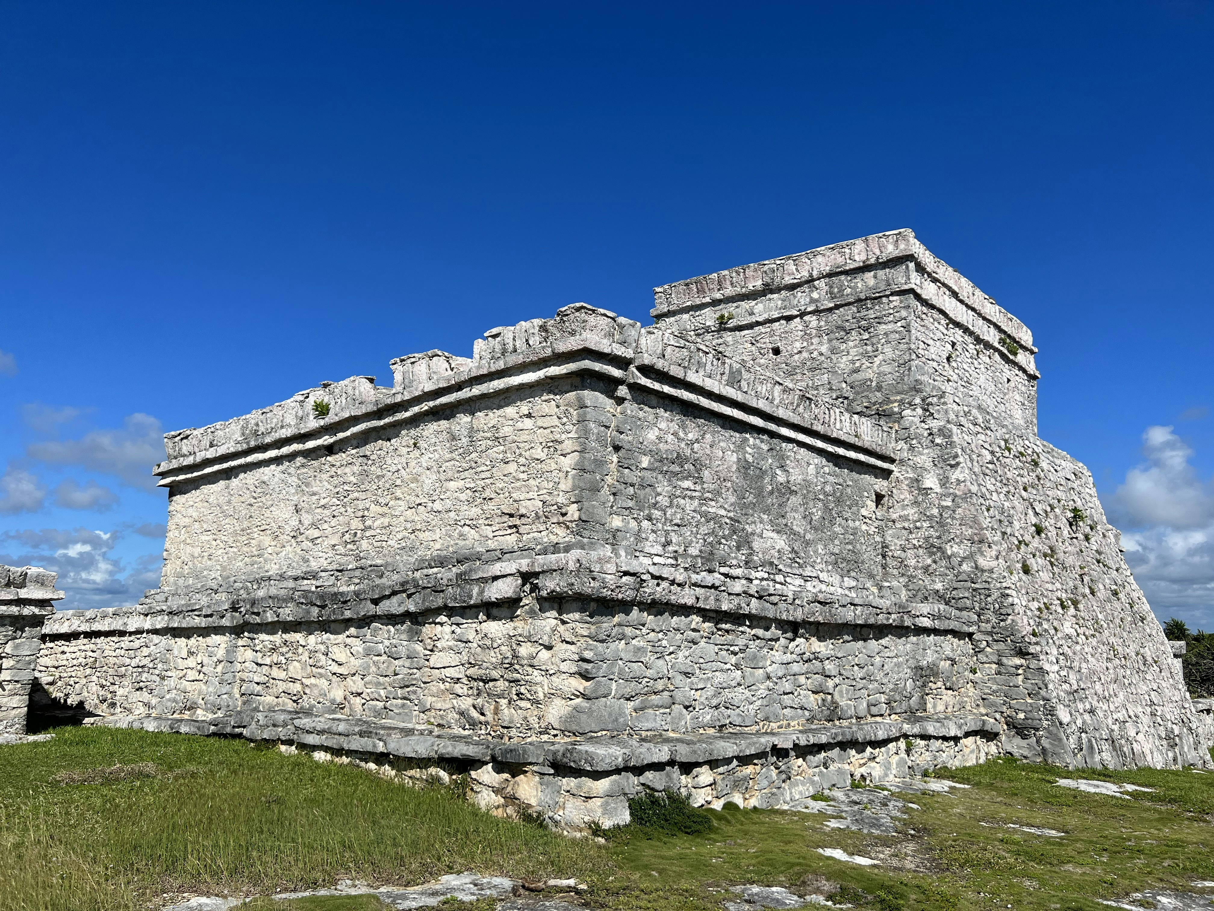 A large stone structure sitting on top of a lush green field photo ...