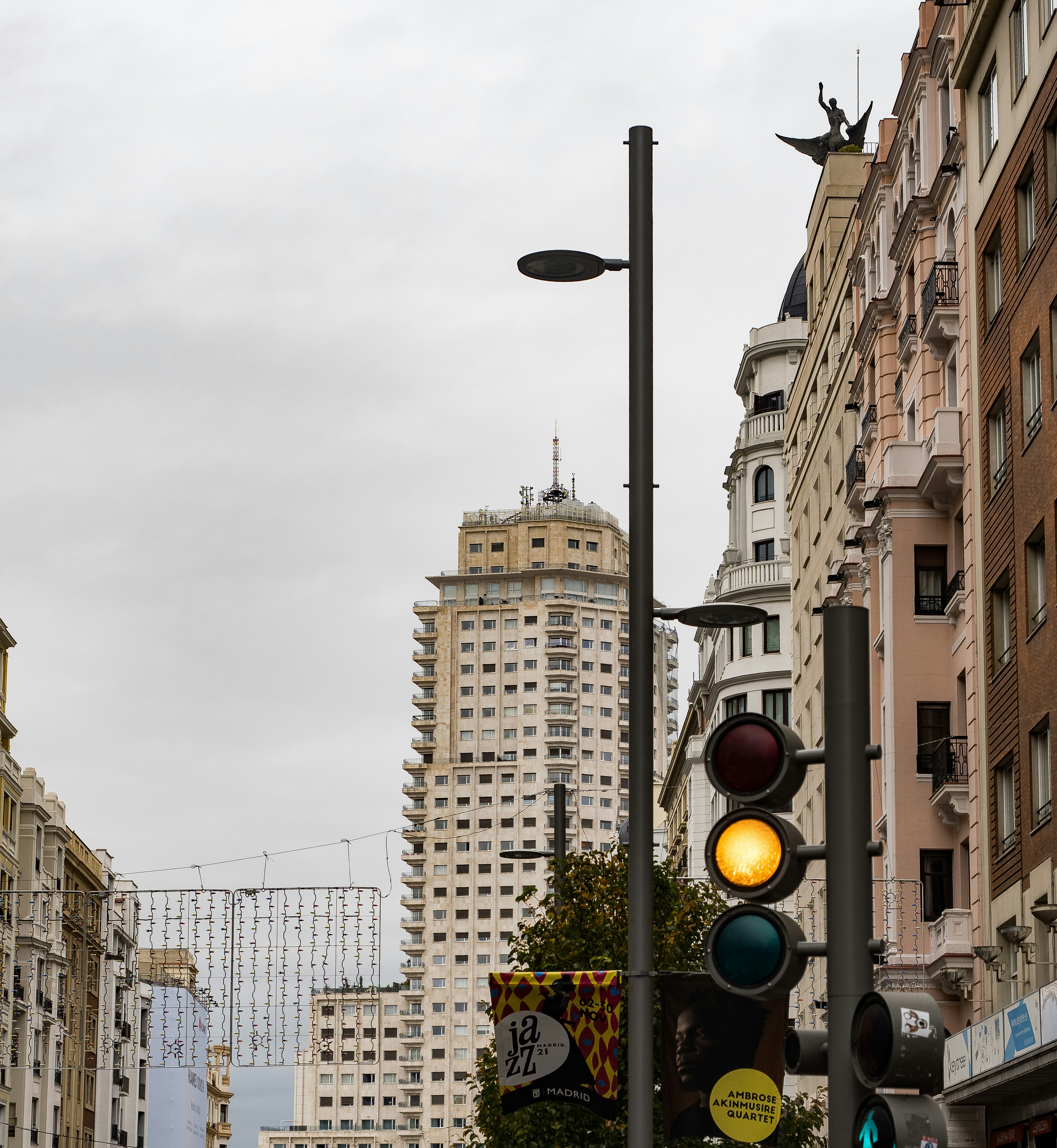 A traffic light on a city street with tall buildings in the background ...