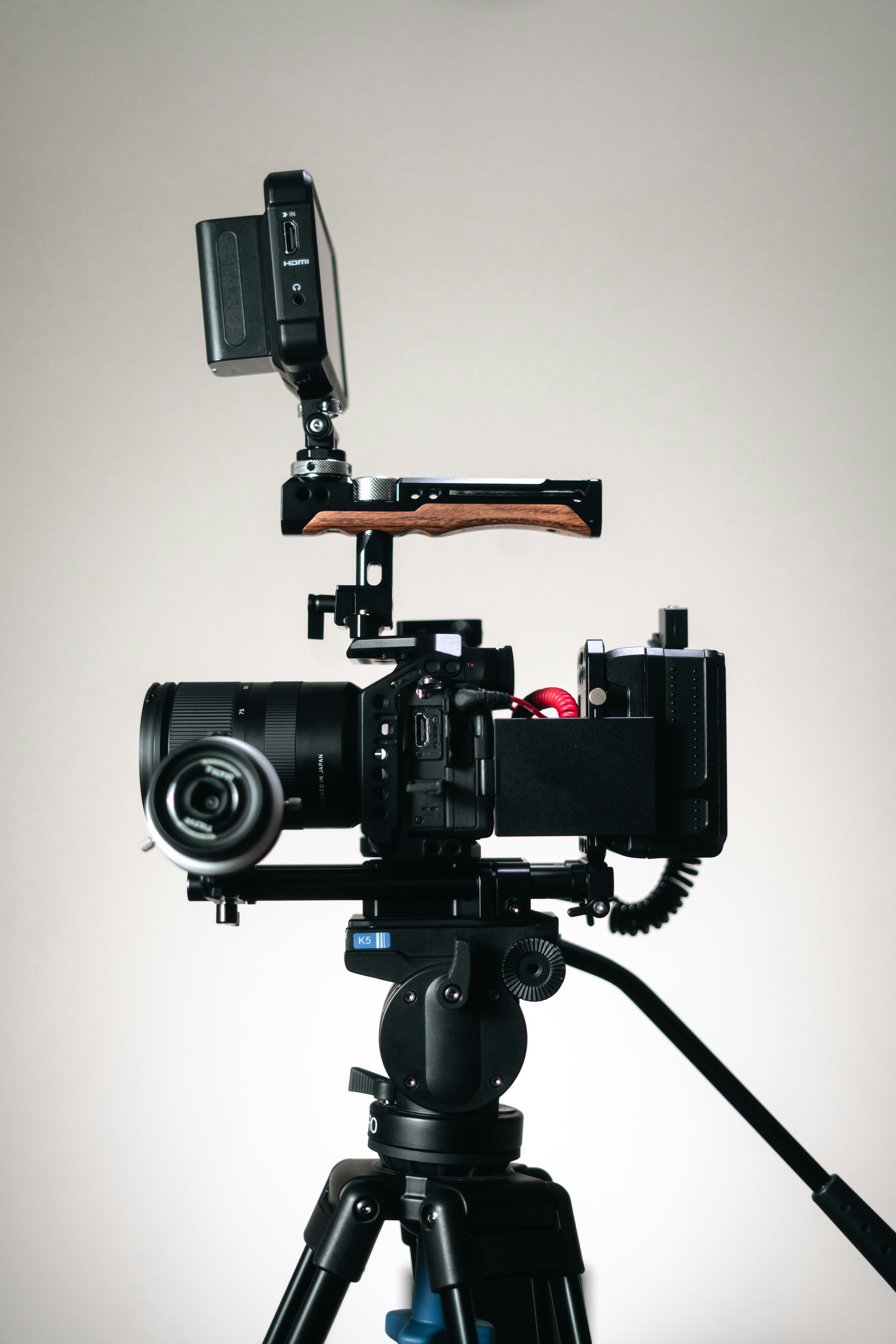 Vertical photo of professional video camera set up | a tripod with a camera attached to it
