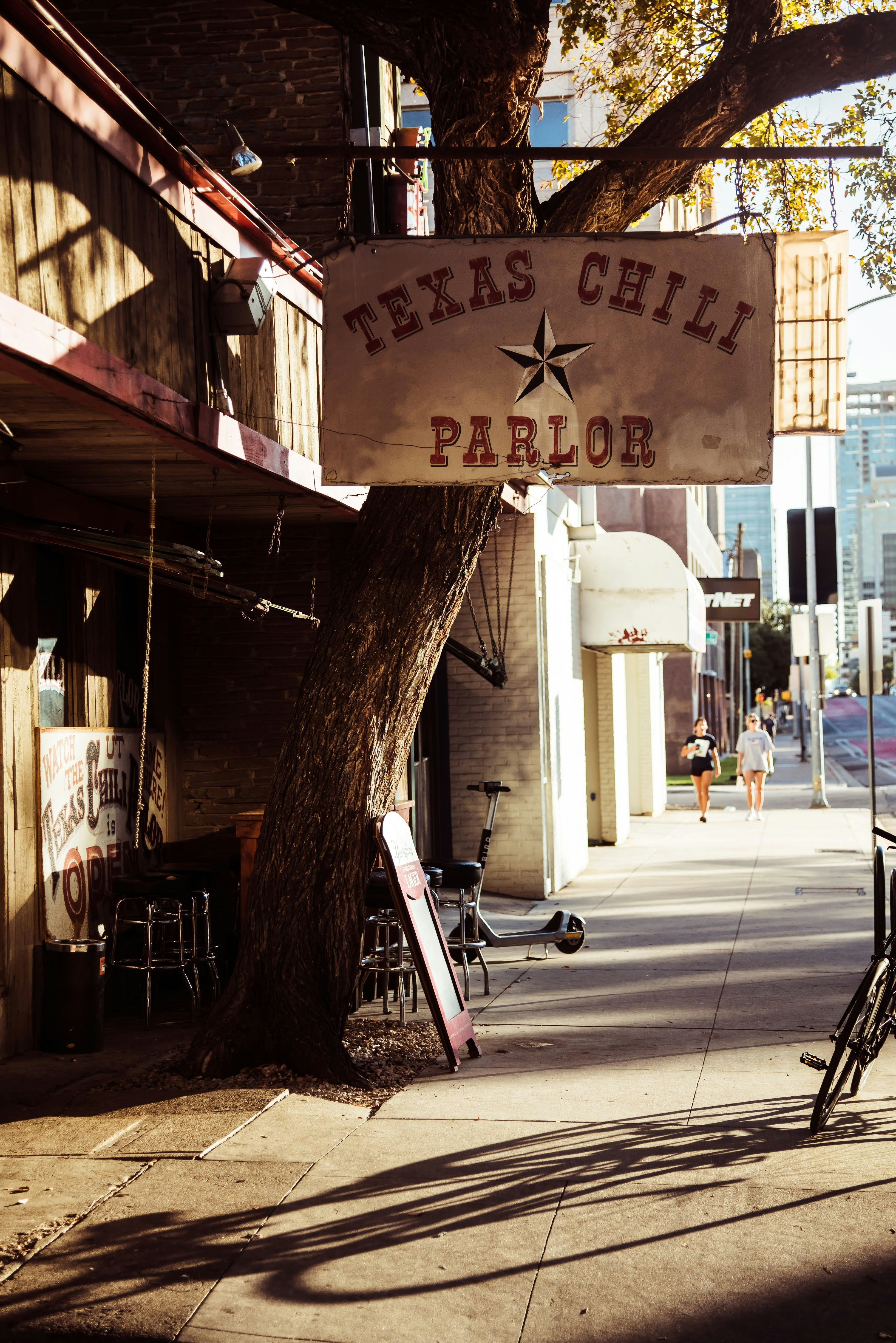 a texas chili parlor sign hanging from the side of a building