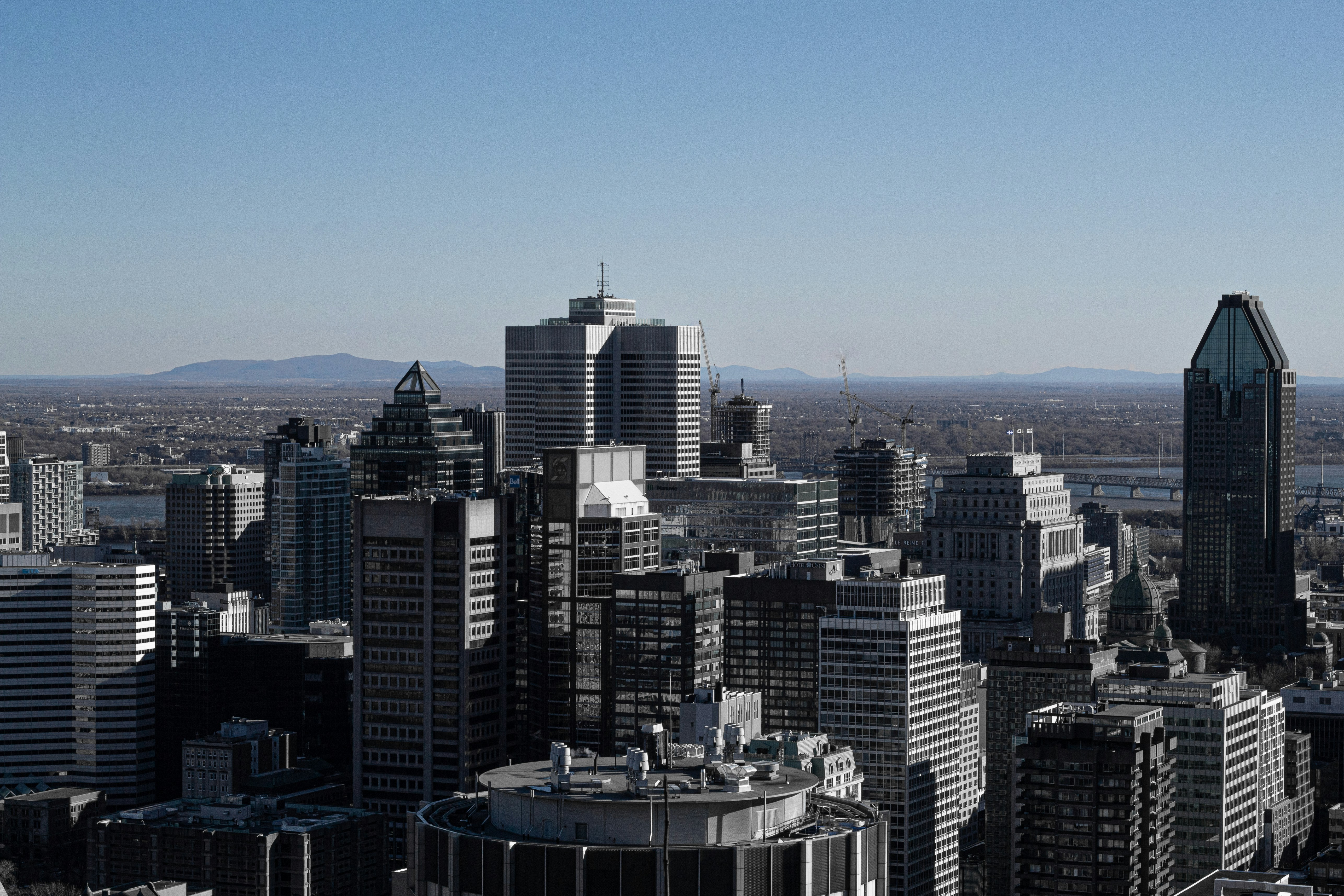 Montreal skyline with a clear blue sky and distant mountains.