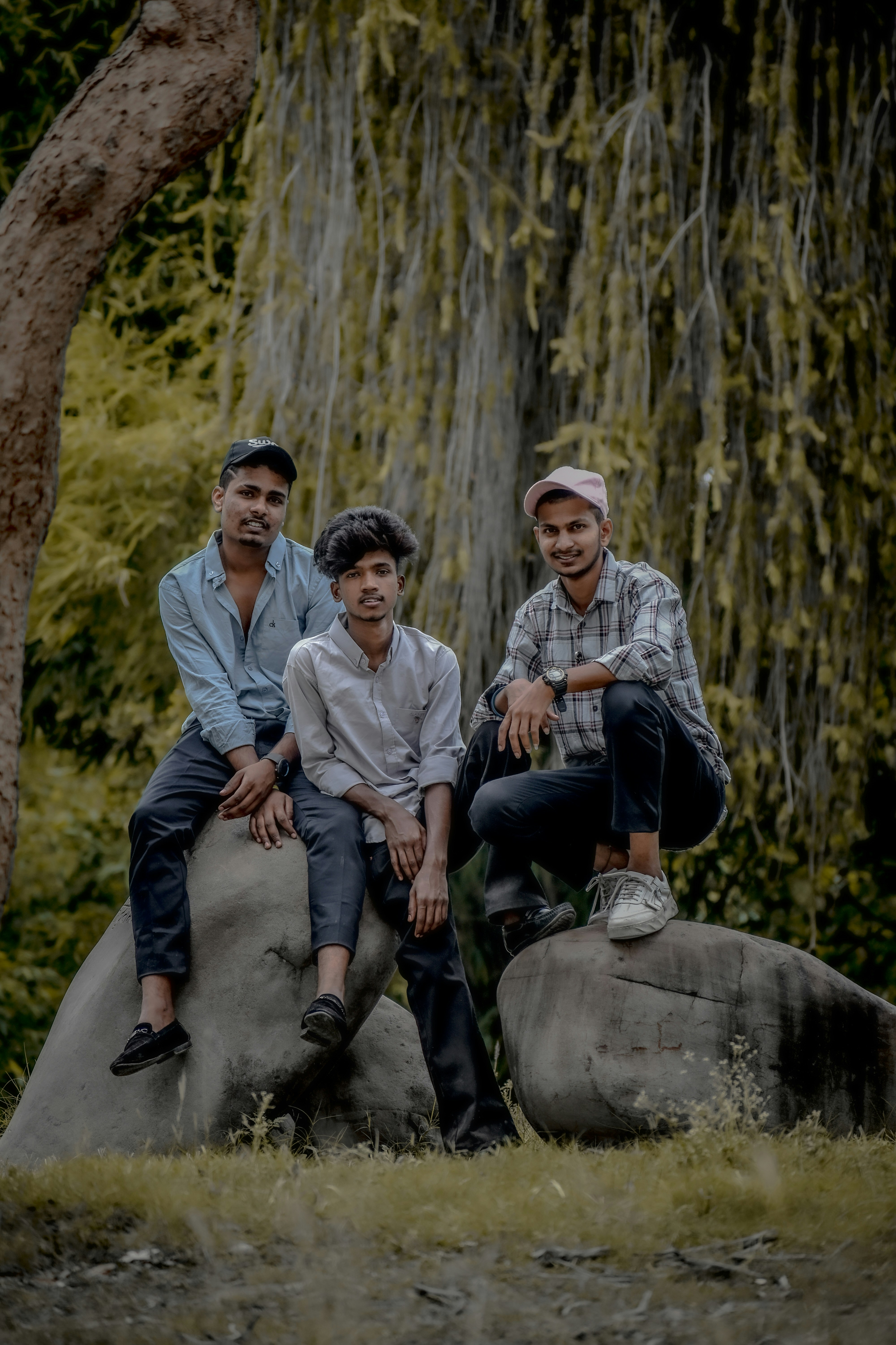 A group of three men sitting on top of a rock photo – Free Clothing ...