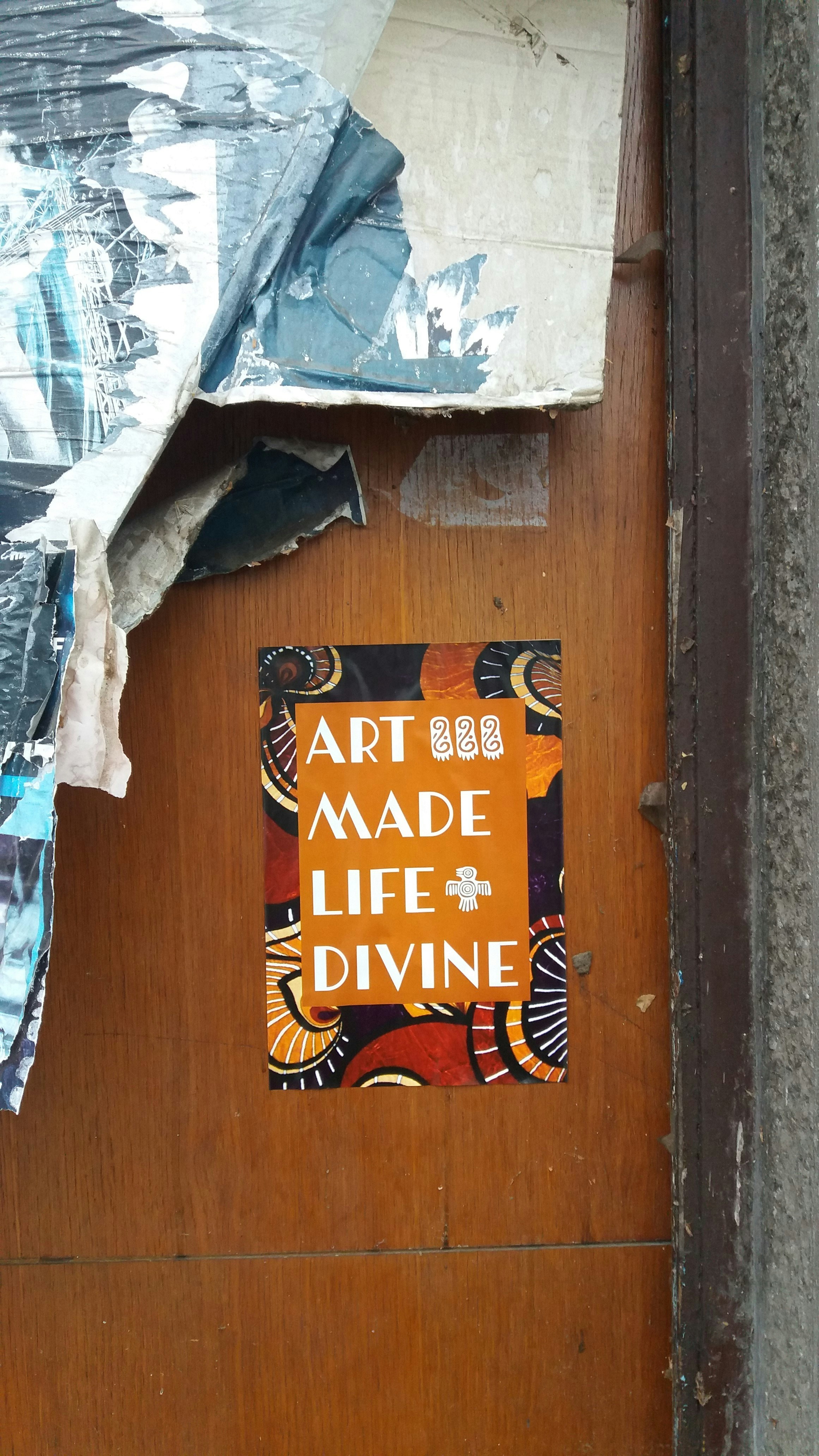 ART 2022 MADE LIFE DIVINE: An Orange Square Poster on a Weathered Door