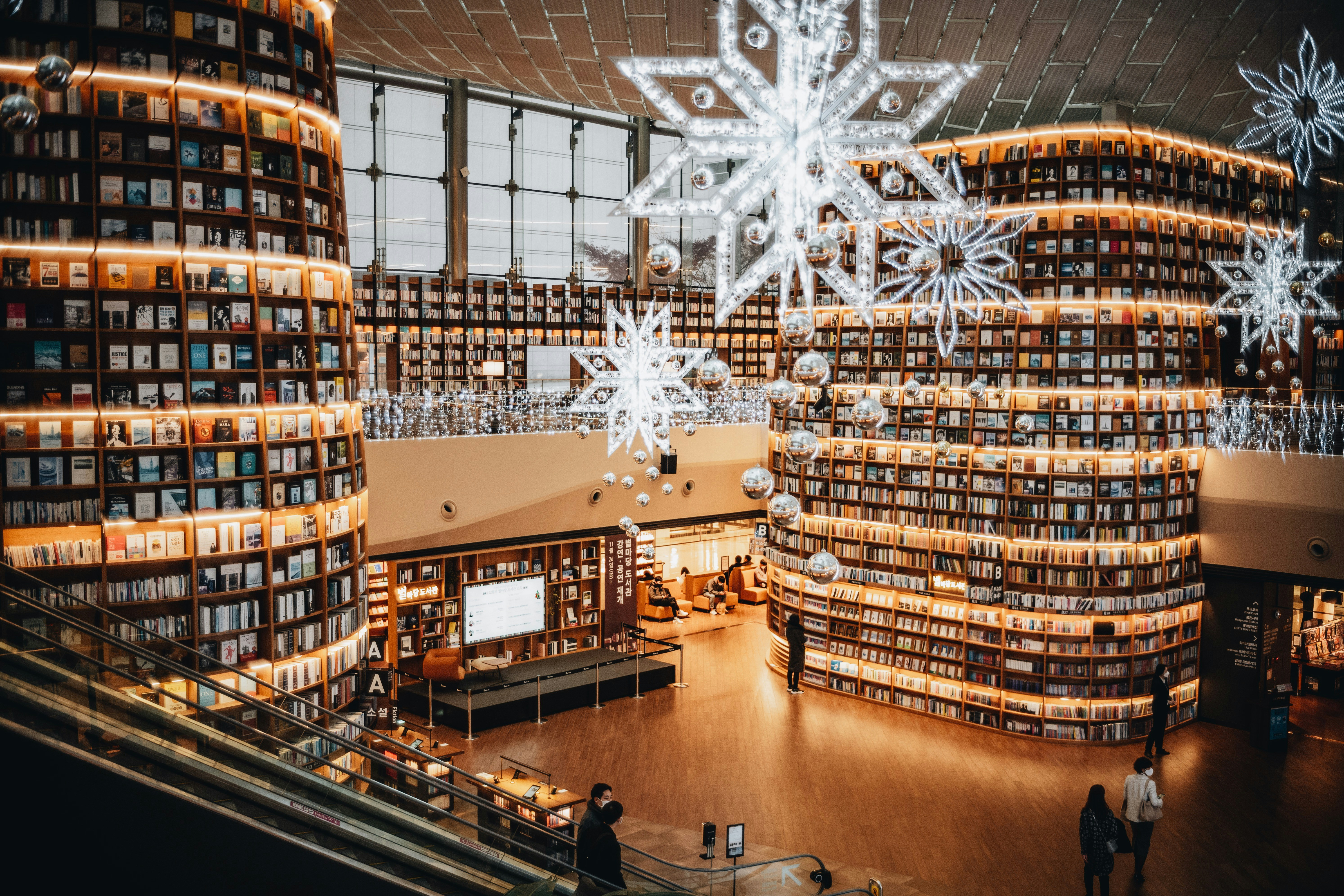 A large library filled with lots of books photo – Free Human Image on ...