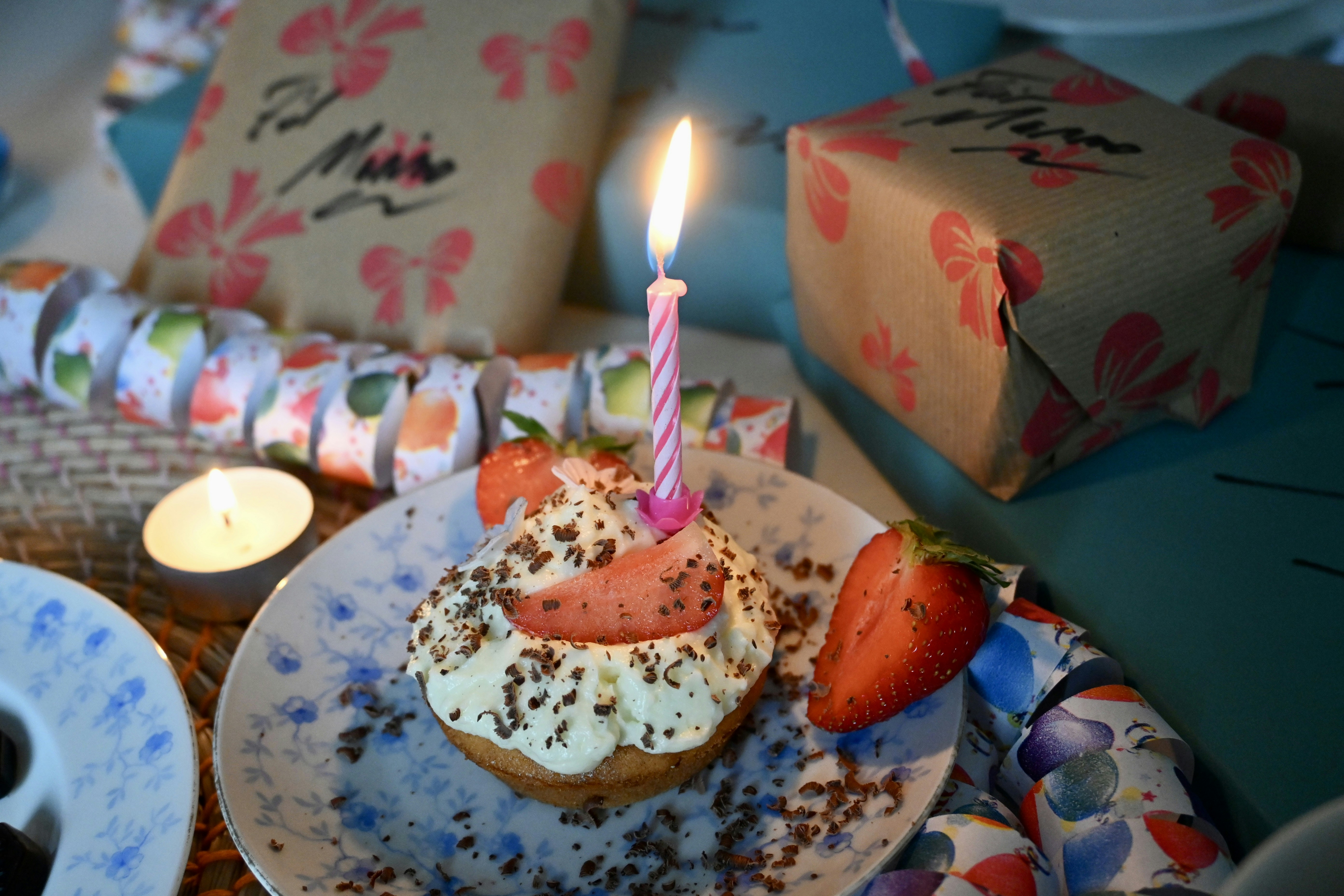 a birthday cake with a lit candle on a plate