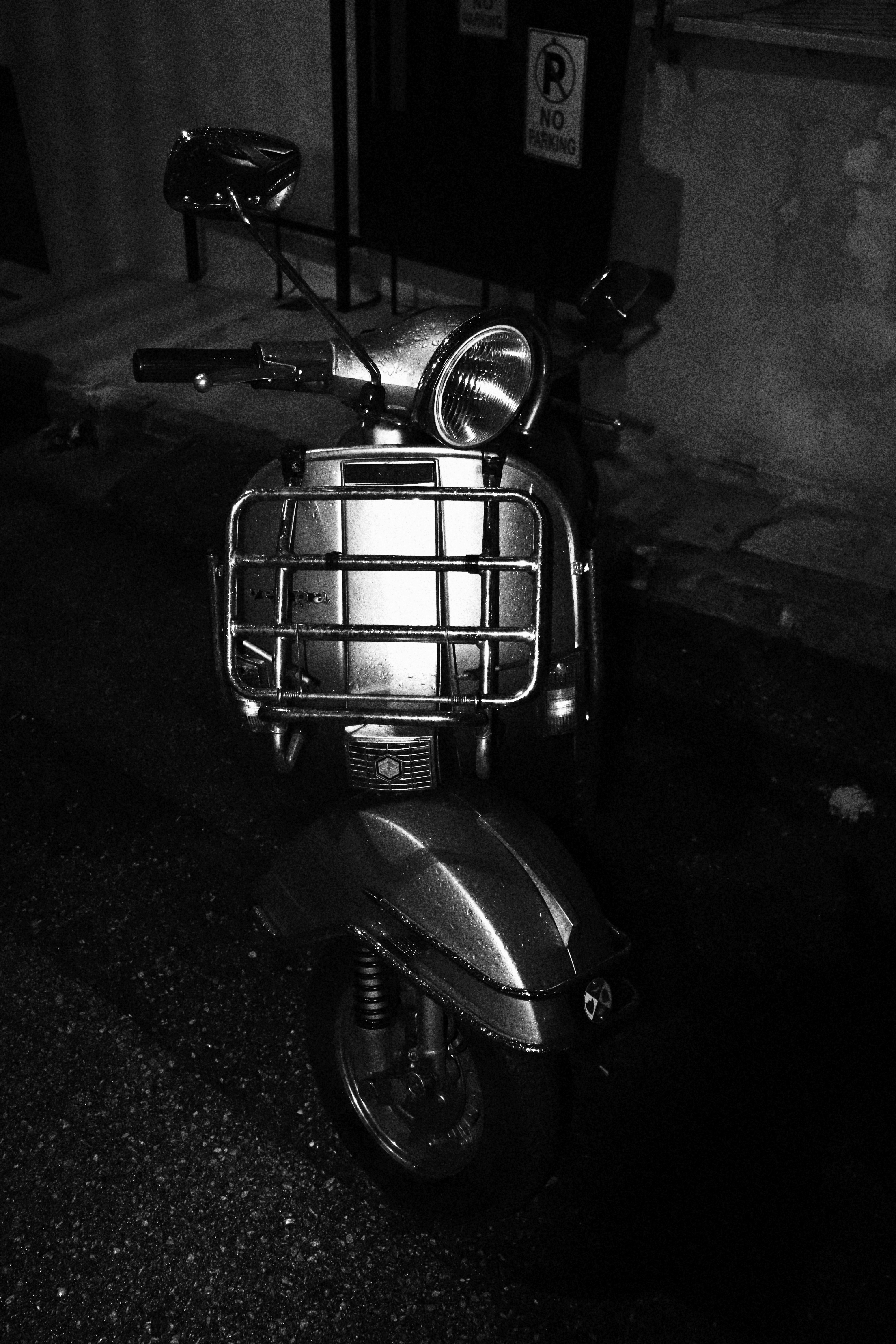 Nocturnal Front: chrome scooter anchored in a dim urban alley