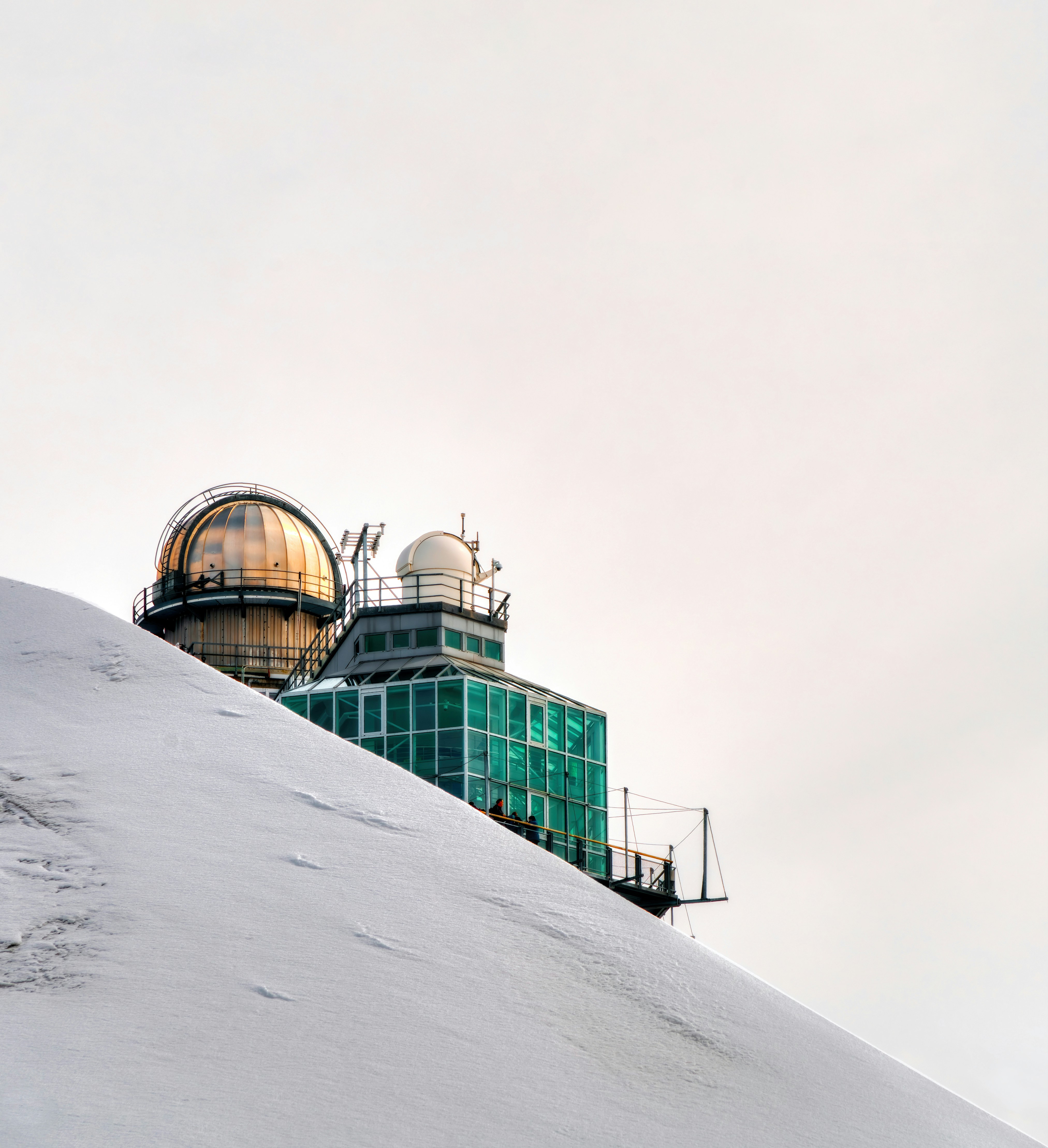 Turquoise Glass on White Slope: A Remote Observatory Clings to the Ridge