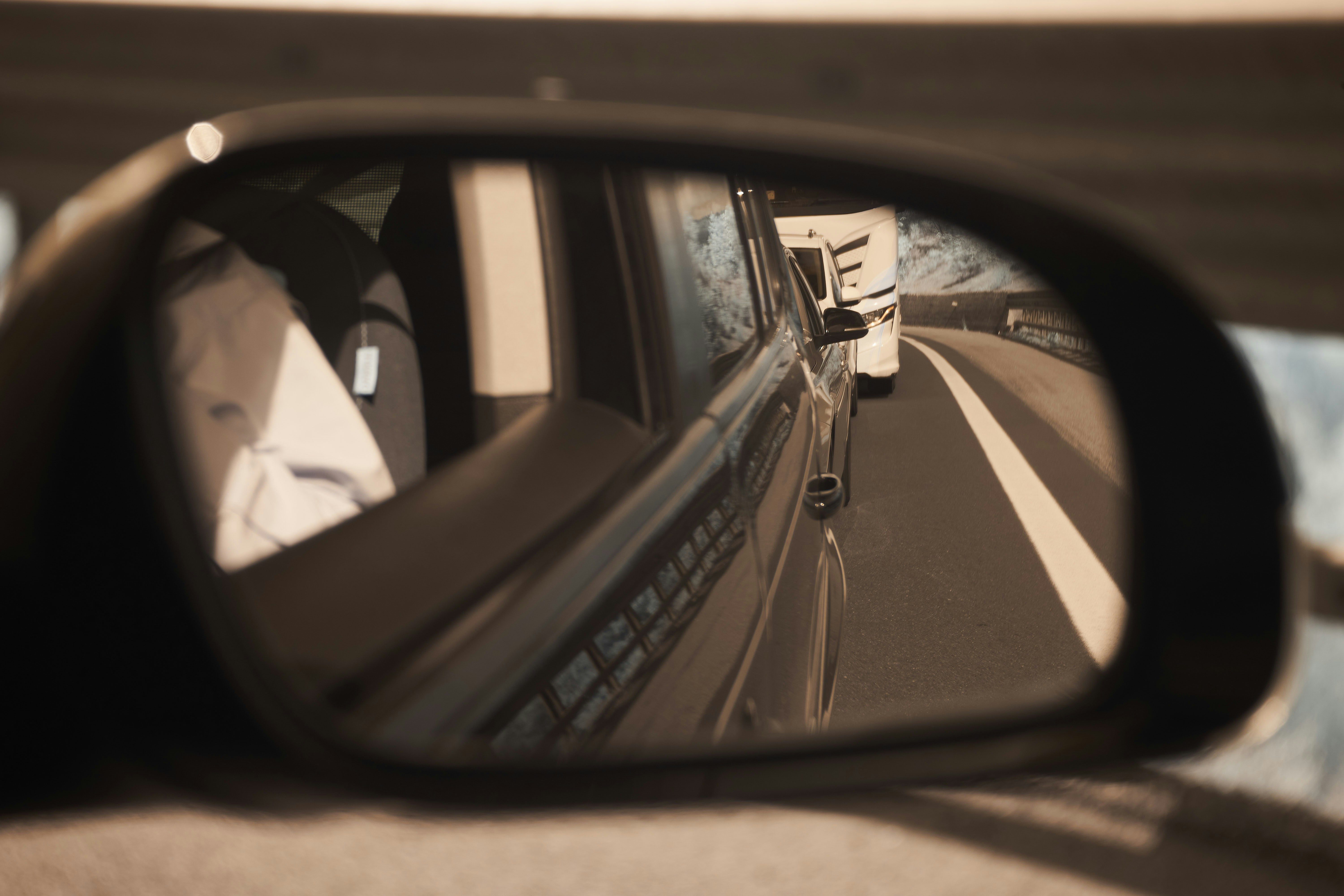 Reflections on the Road: A Passing Car Framed by the Side Mirror