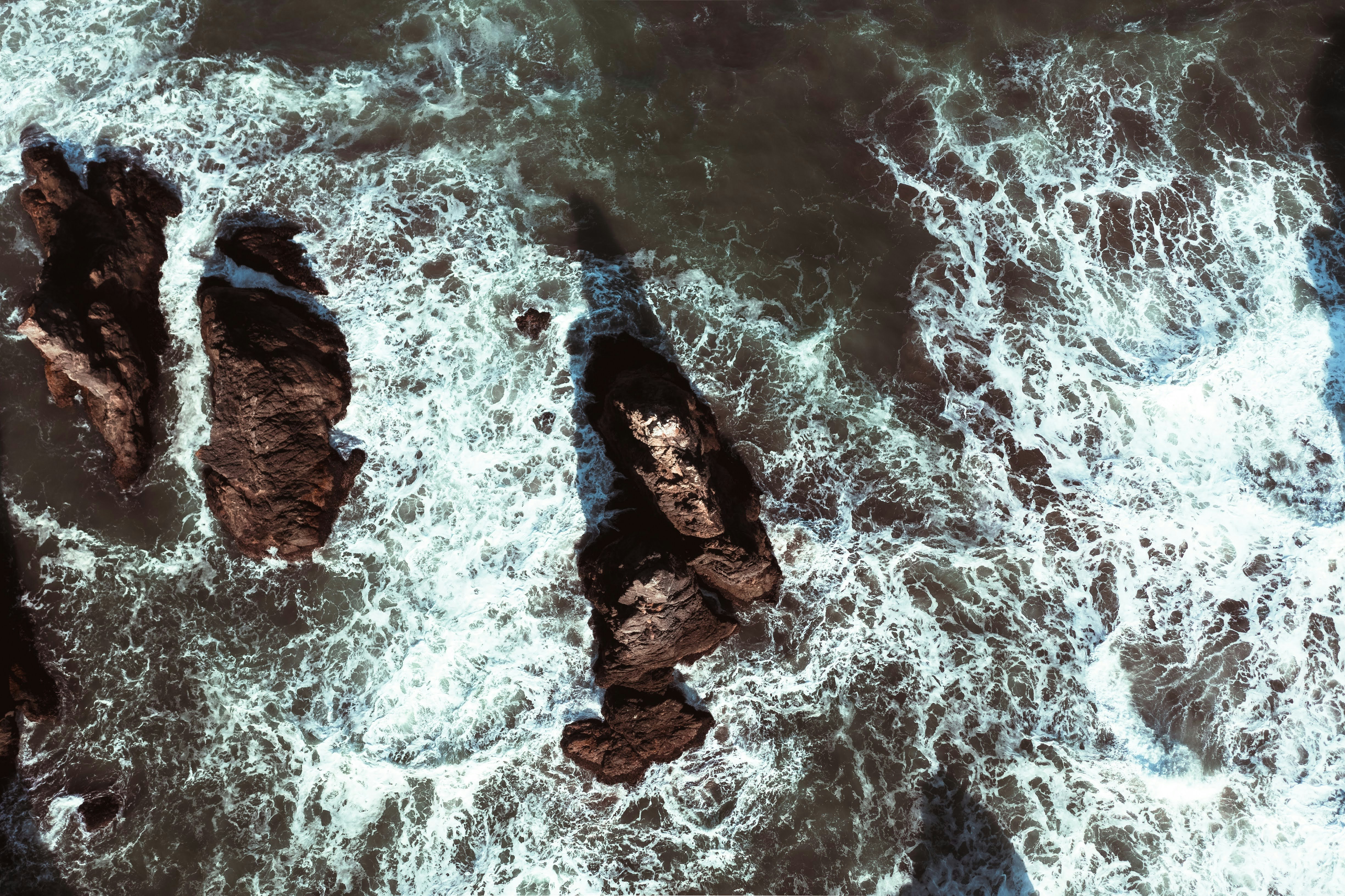 Rugged Breakers: Exposed Rock Islets Amidst Rolling White Foams
