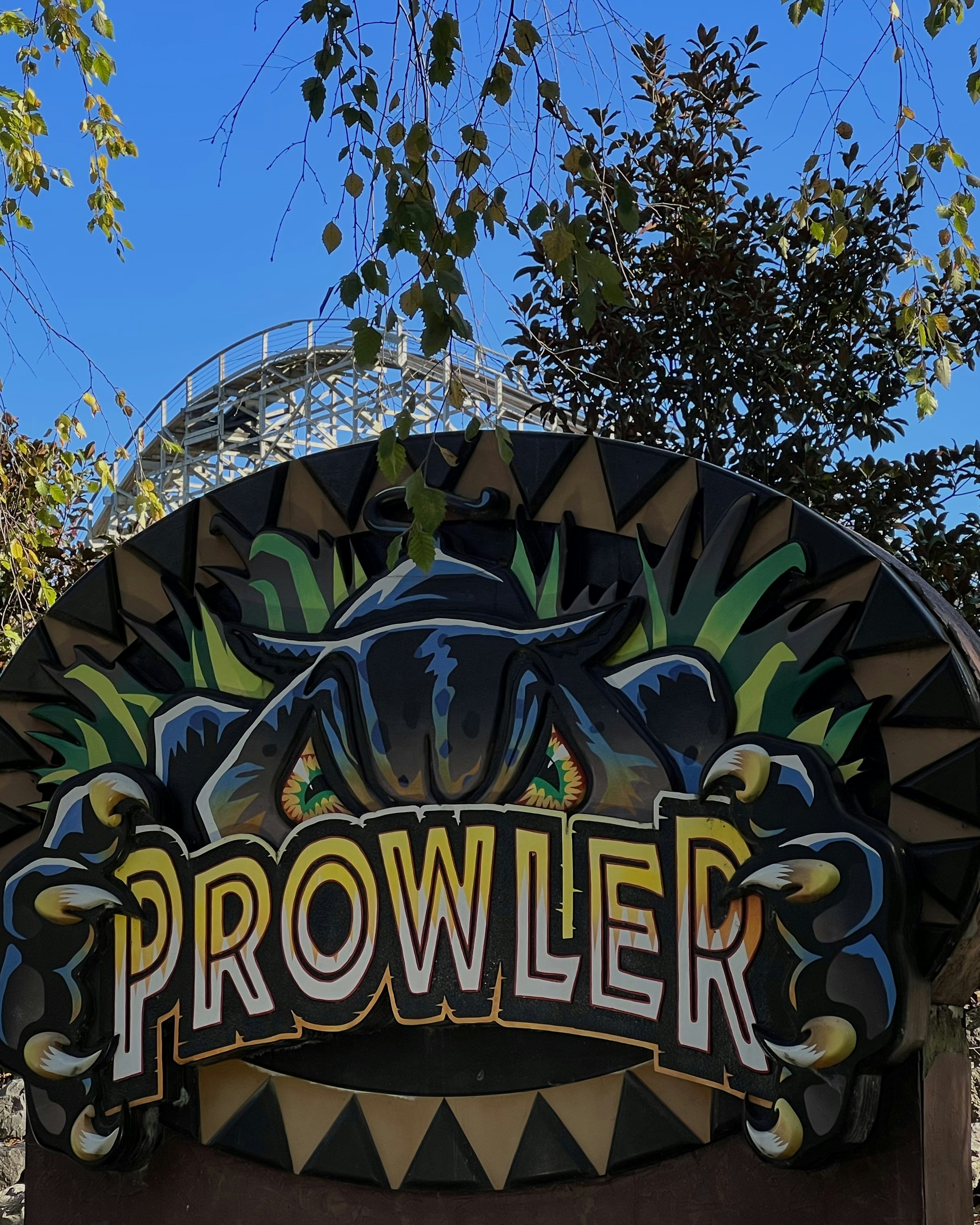 Prowler Sign: Monster Graffiti Crowned by Foliage Under a Bright Sky