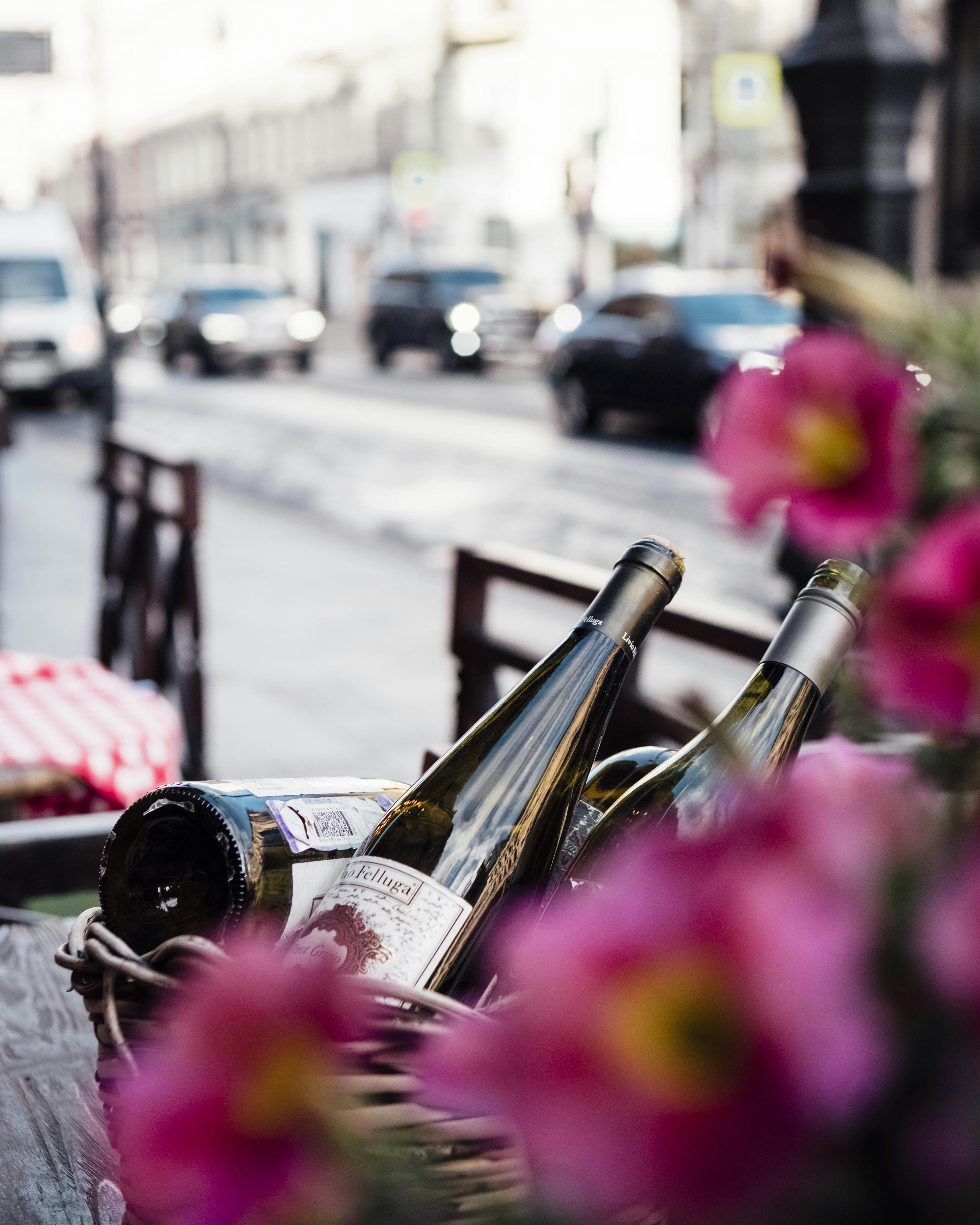 Bottles in Bloom: Sunlit Still Life Framed by City Motion