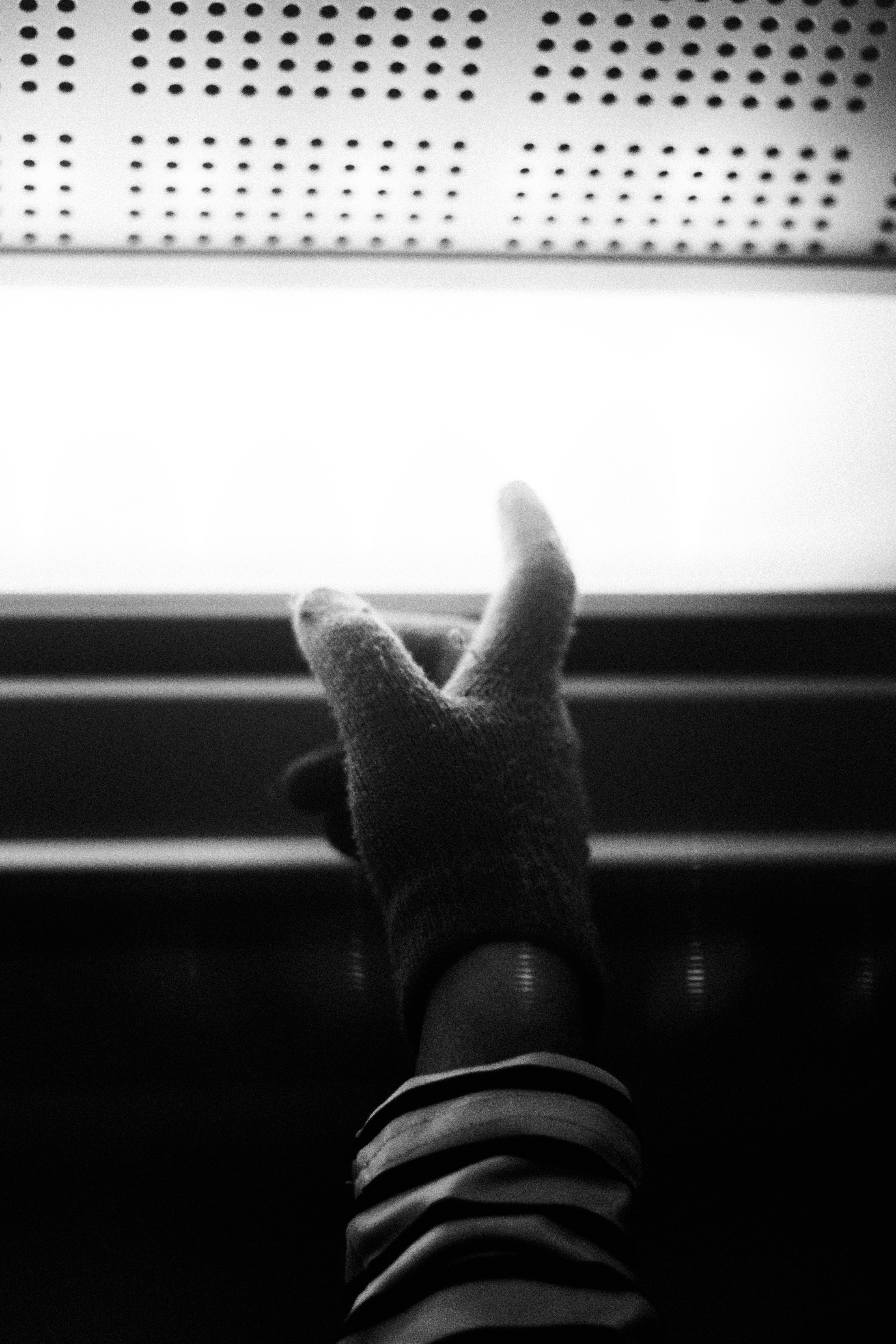 Gloved hand reaching towards a bright light source, juxtaposed against a dark background. The scene captures a moment of curiosity and exploration.