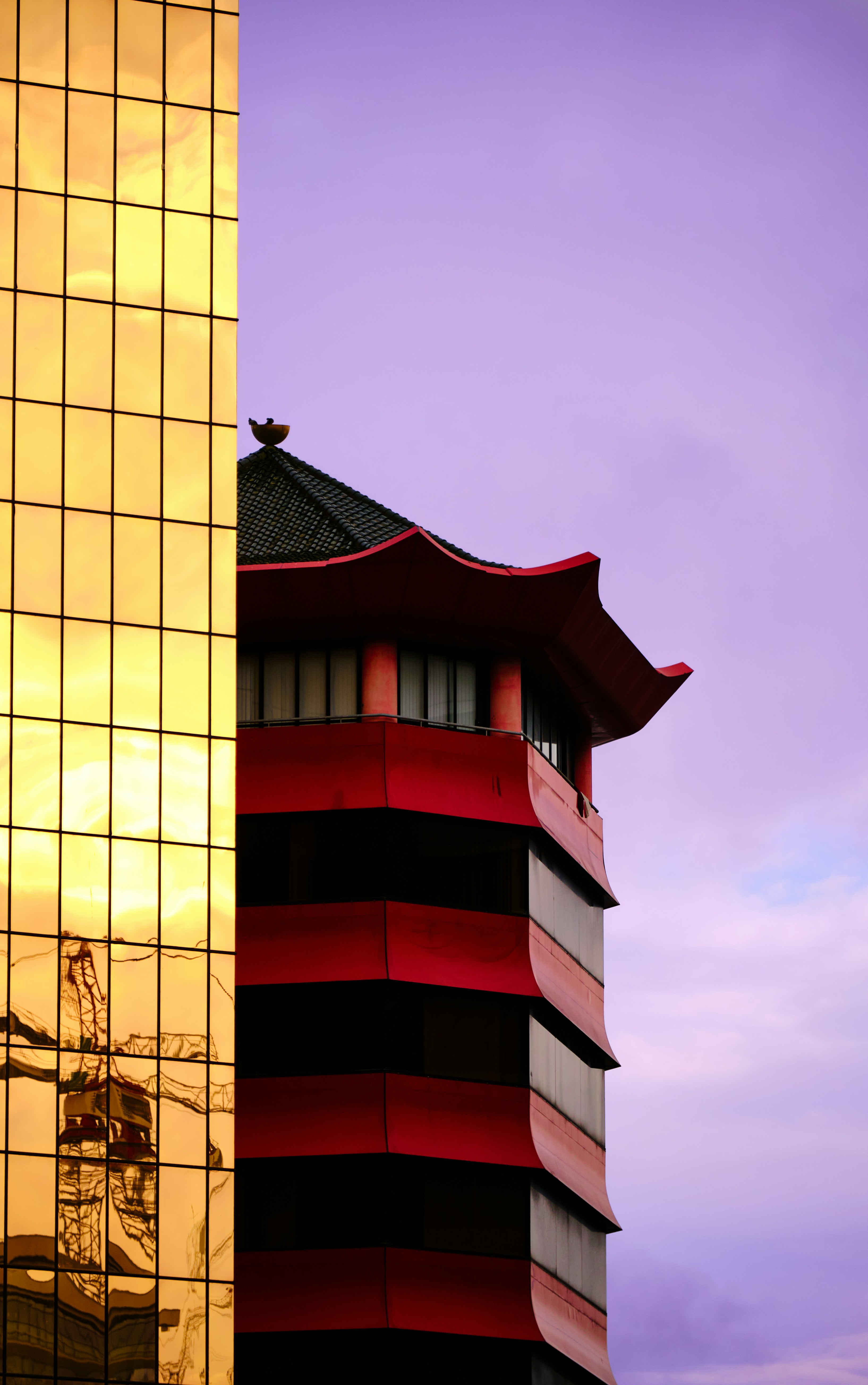 a tall building with a red roof next to a tall building