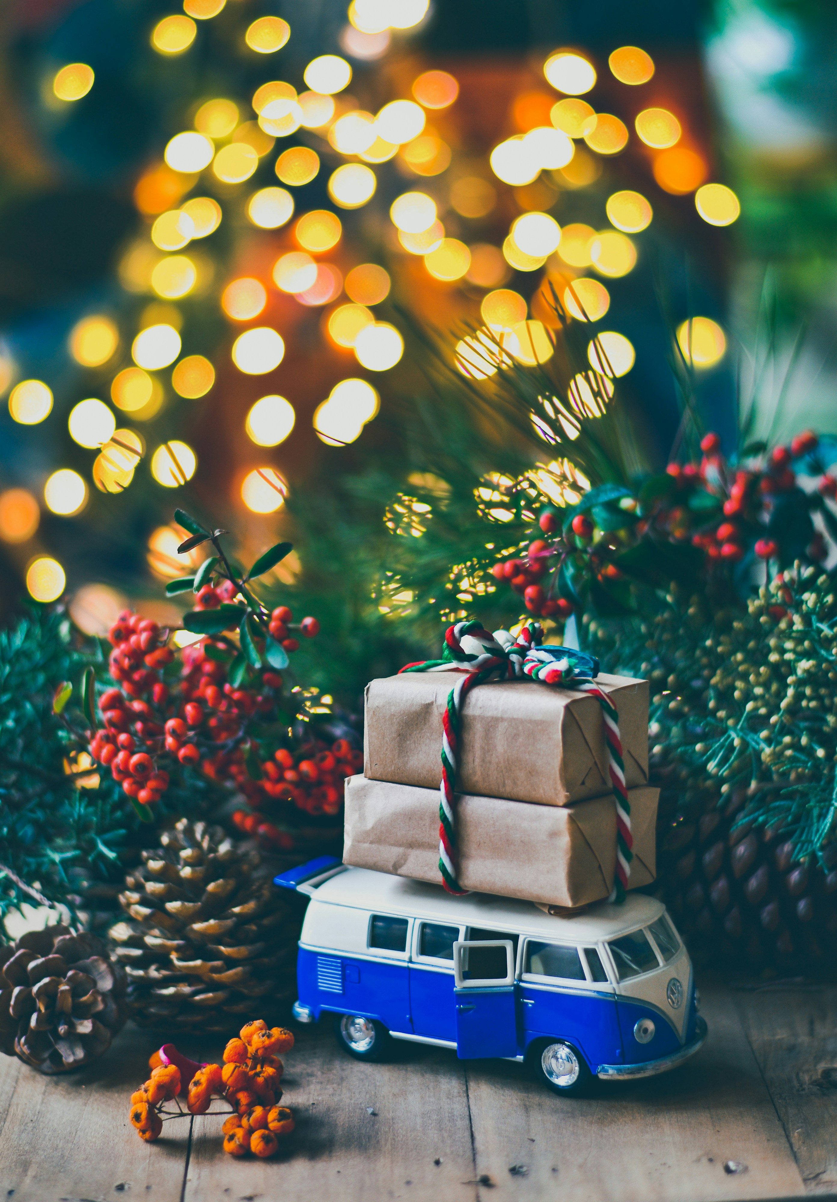 Miniature Blue Bus Bedecked with Gifts Under Soft Holiday Lights