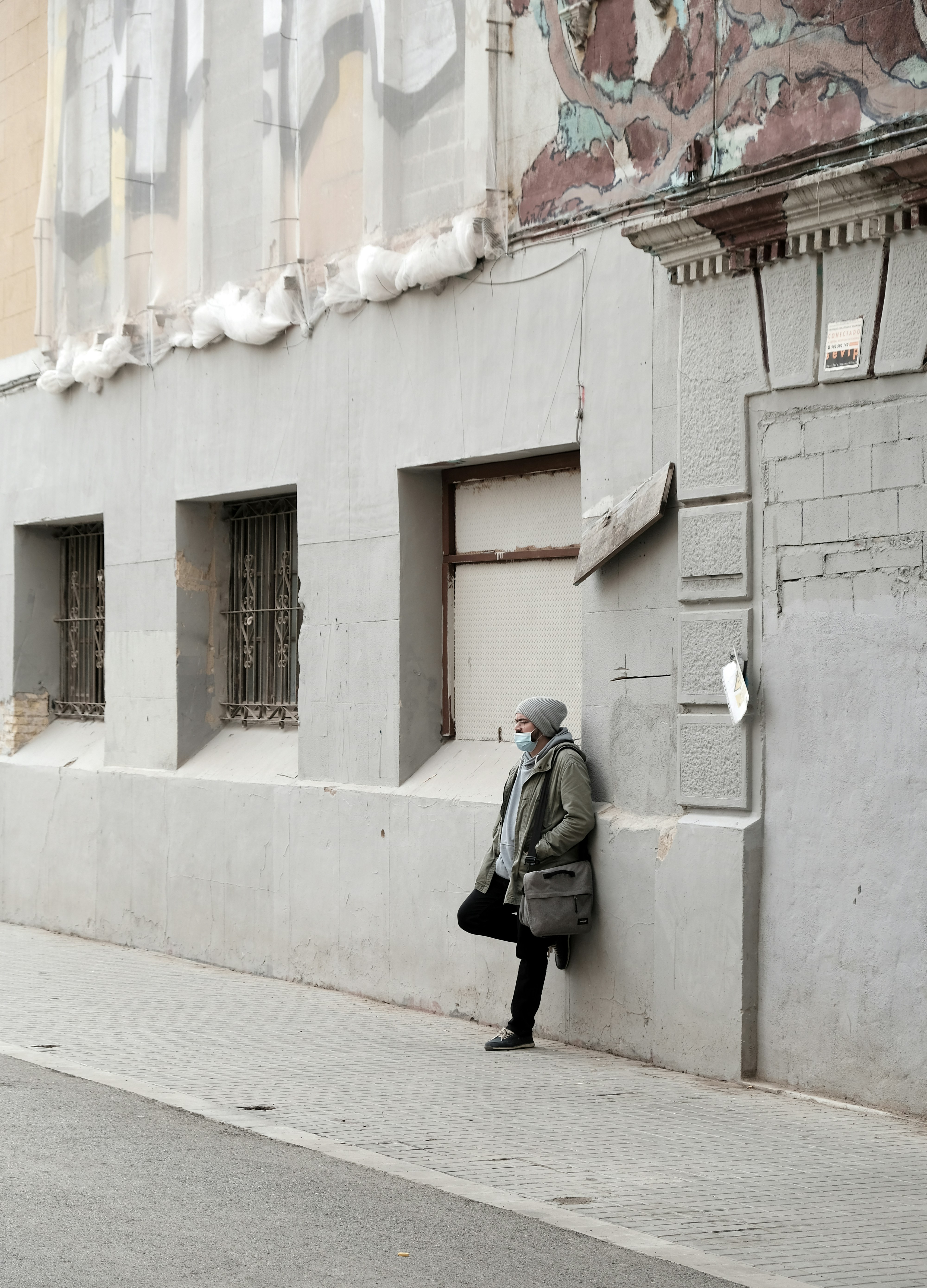 Masked Figure by a Weathered Façade: A Quiet Street Portrait