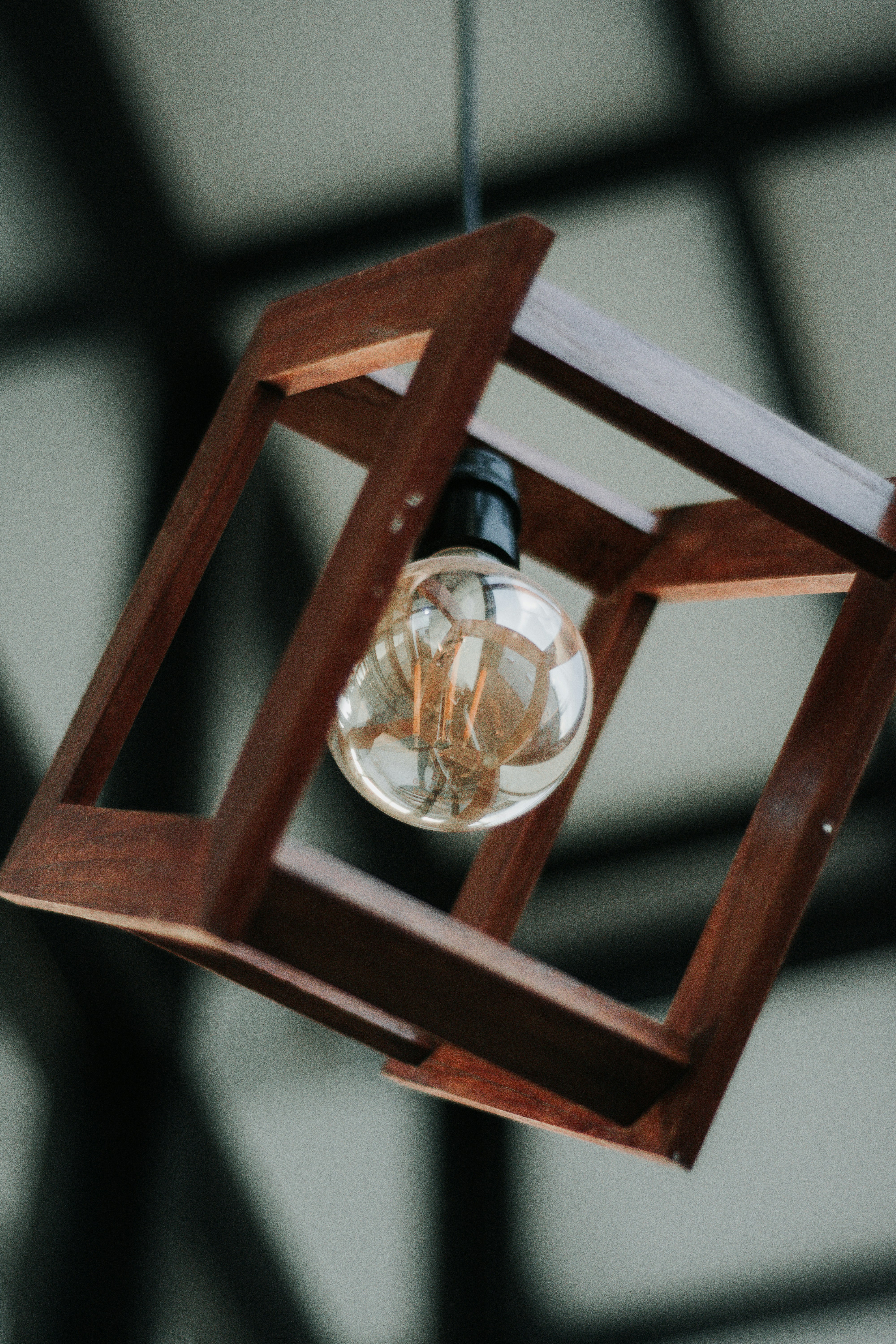 Hanging Lantern: A Geometric Wooden Frame Enclosing a Warm Bulb