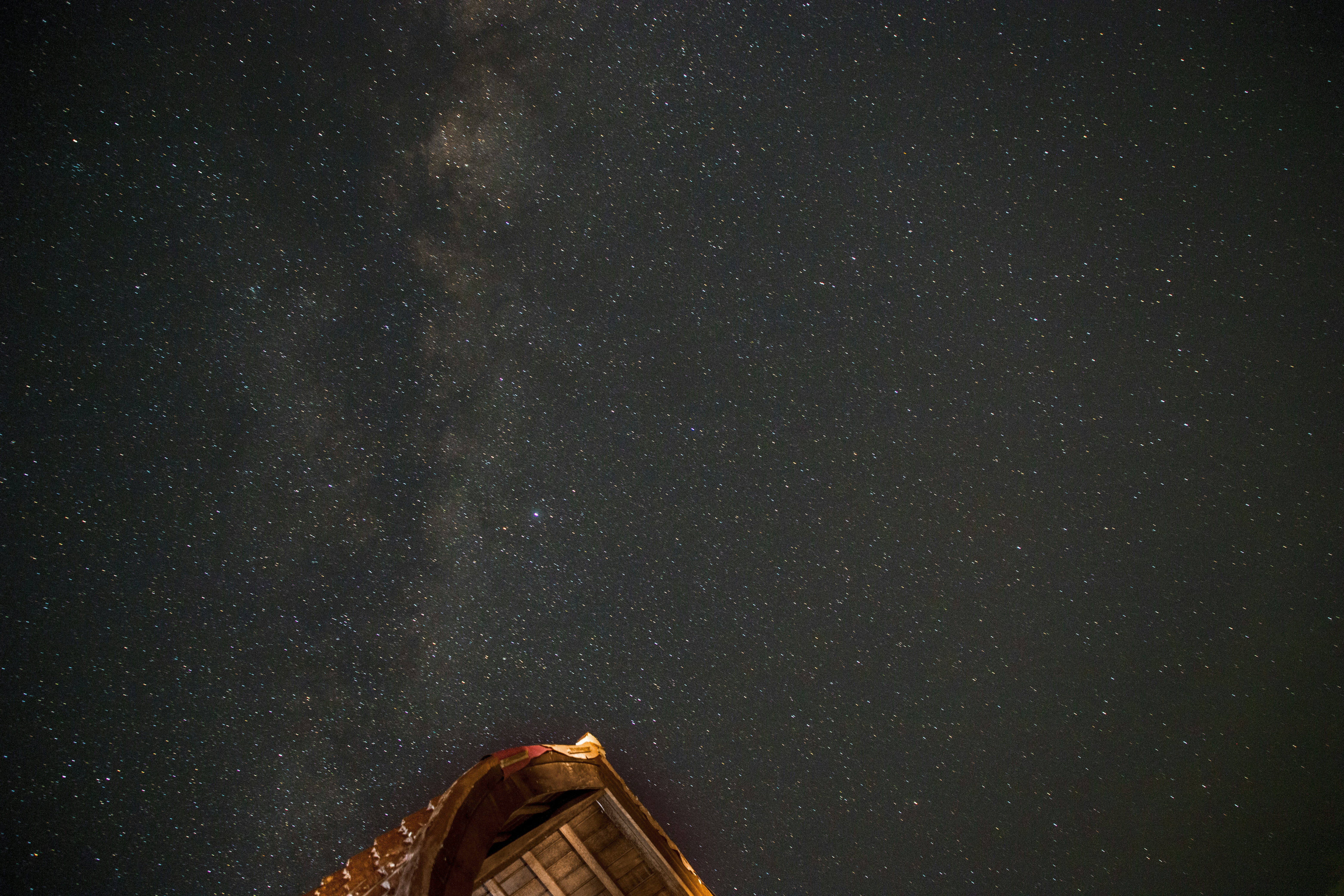 Milky Way Arches Over a Rustic Rooftop