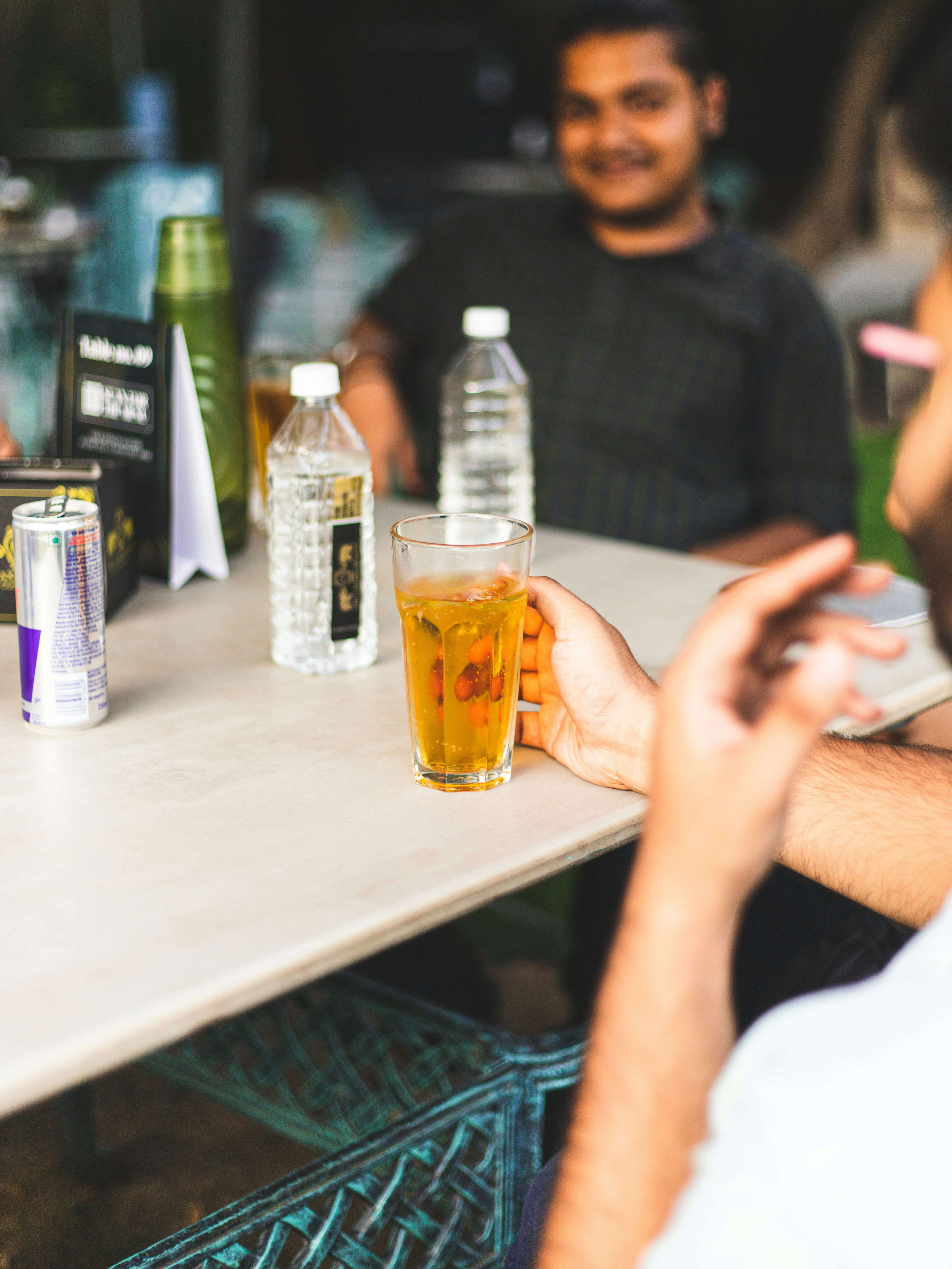 Amber Glass at the Table: A Sharp Focus in a Casual Outdoor Moment