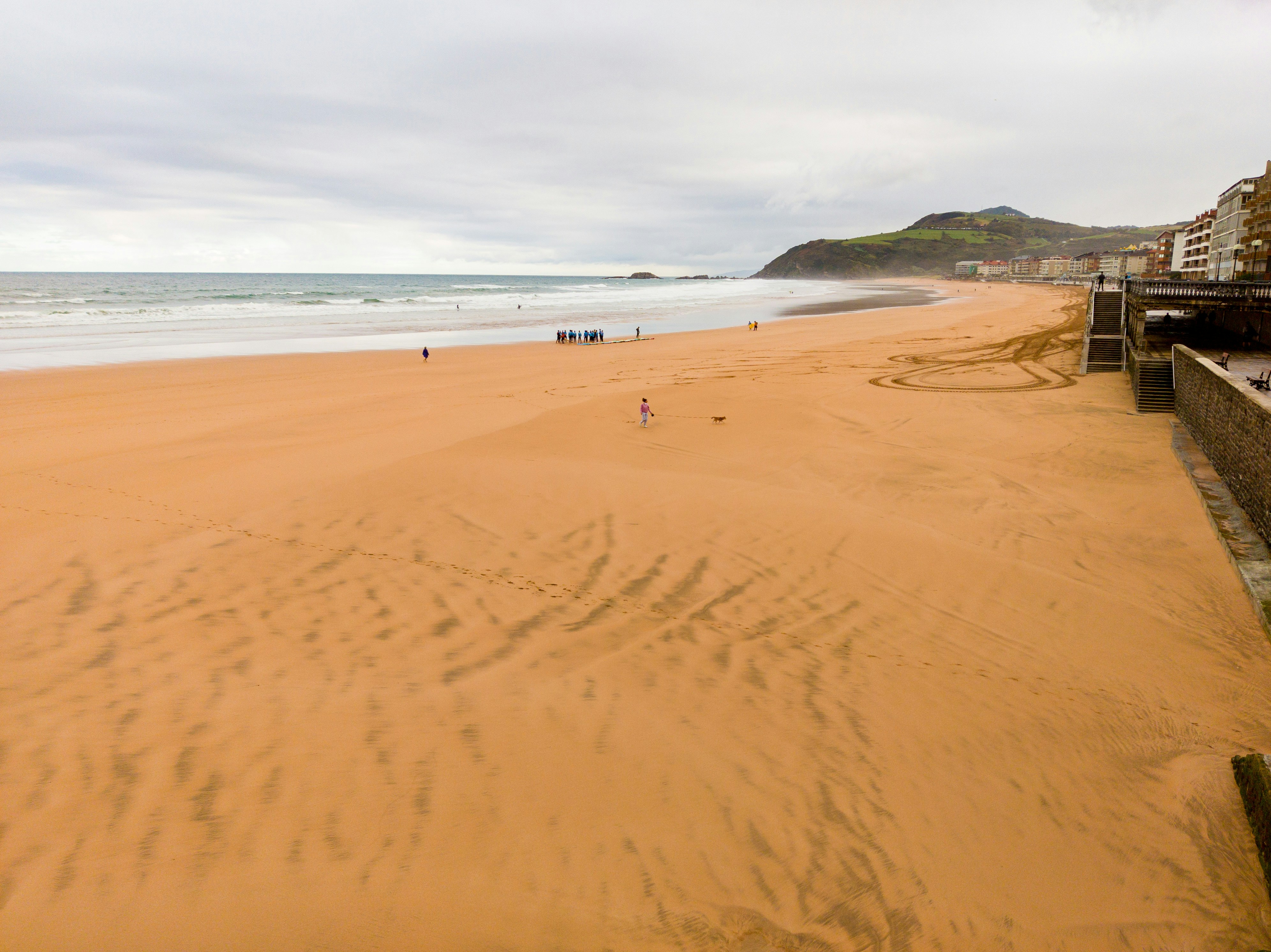 Quiet Shoreline: A Sparse Beach Scene with a Distant Town and Hills
