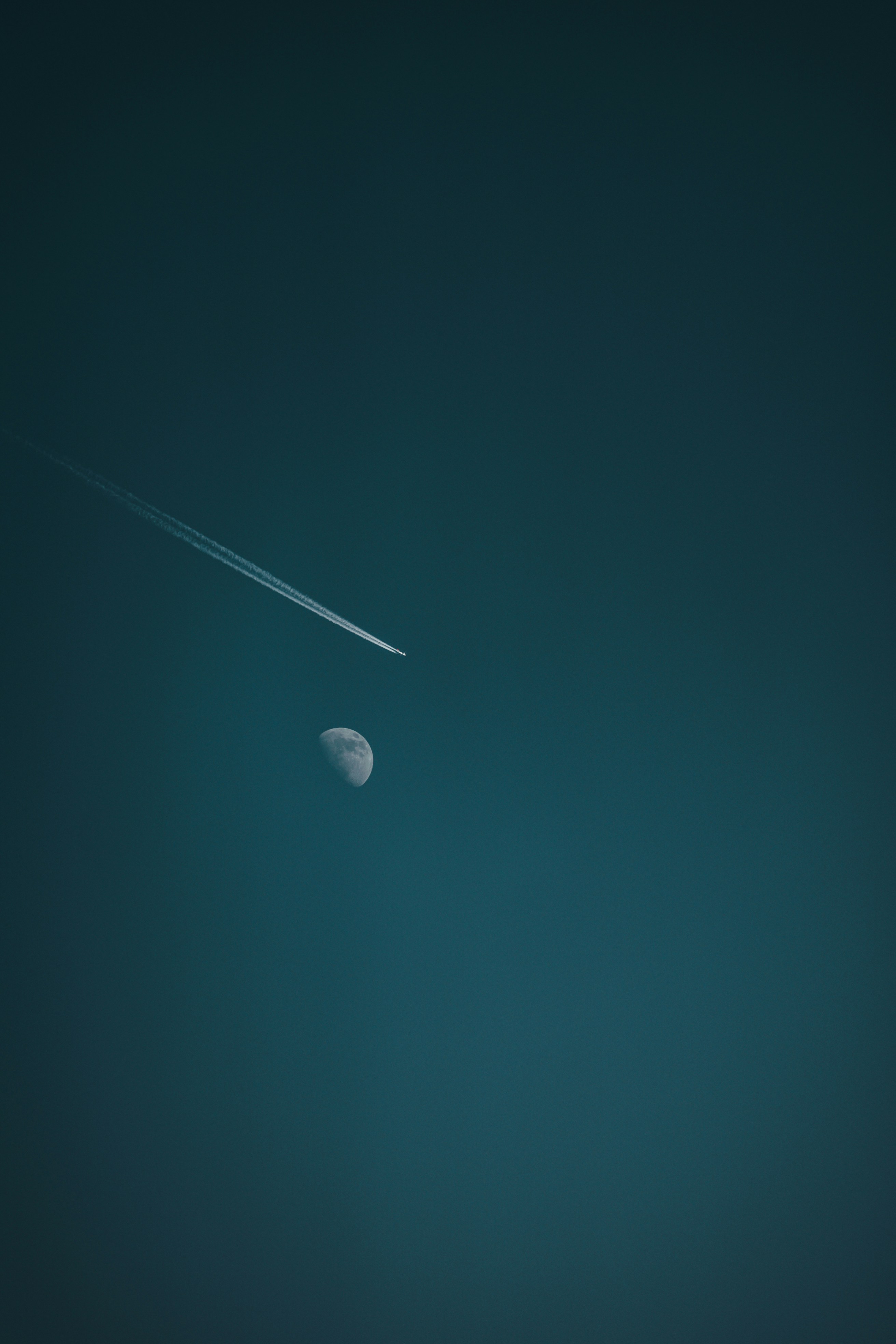 Teal Dusk: Crescent Moon and a Diagonal Contrail