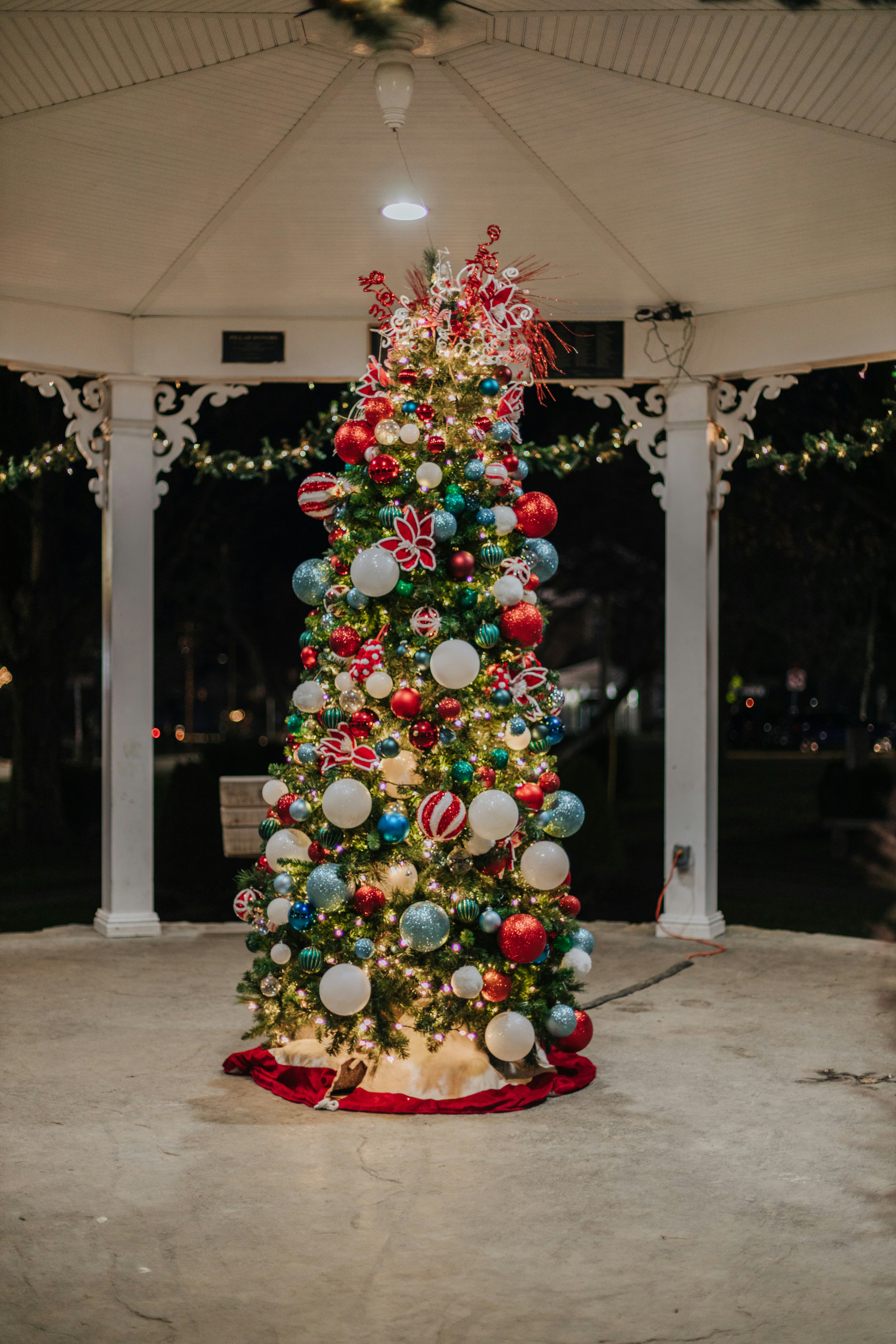 Ornamented Quietude: A Christmas Tree Standing Under a Gazebo's Warm Glow