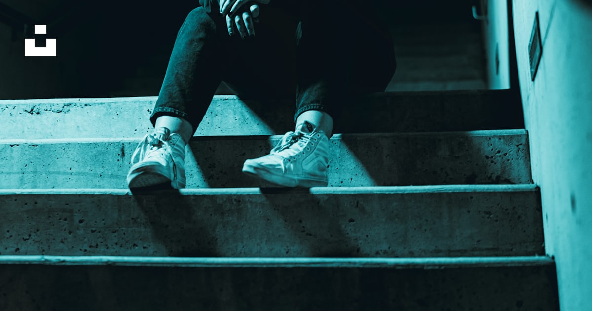 Foto zum Thema Eine maskierte Person sitzt auf einer Treppe ... Foto zum Thema Eine maskierte Person sitzt auf einer Treppe ...