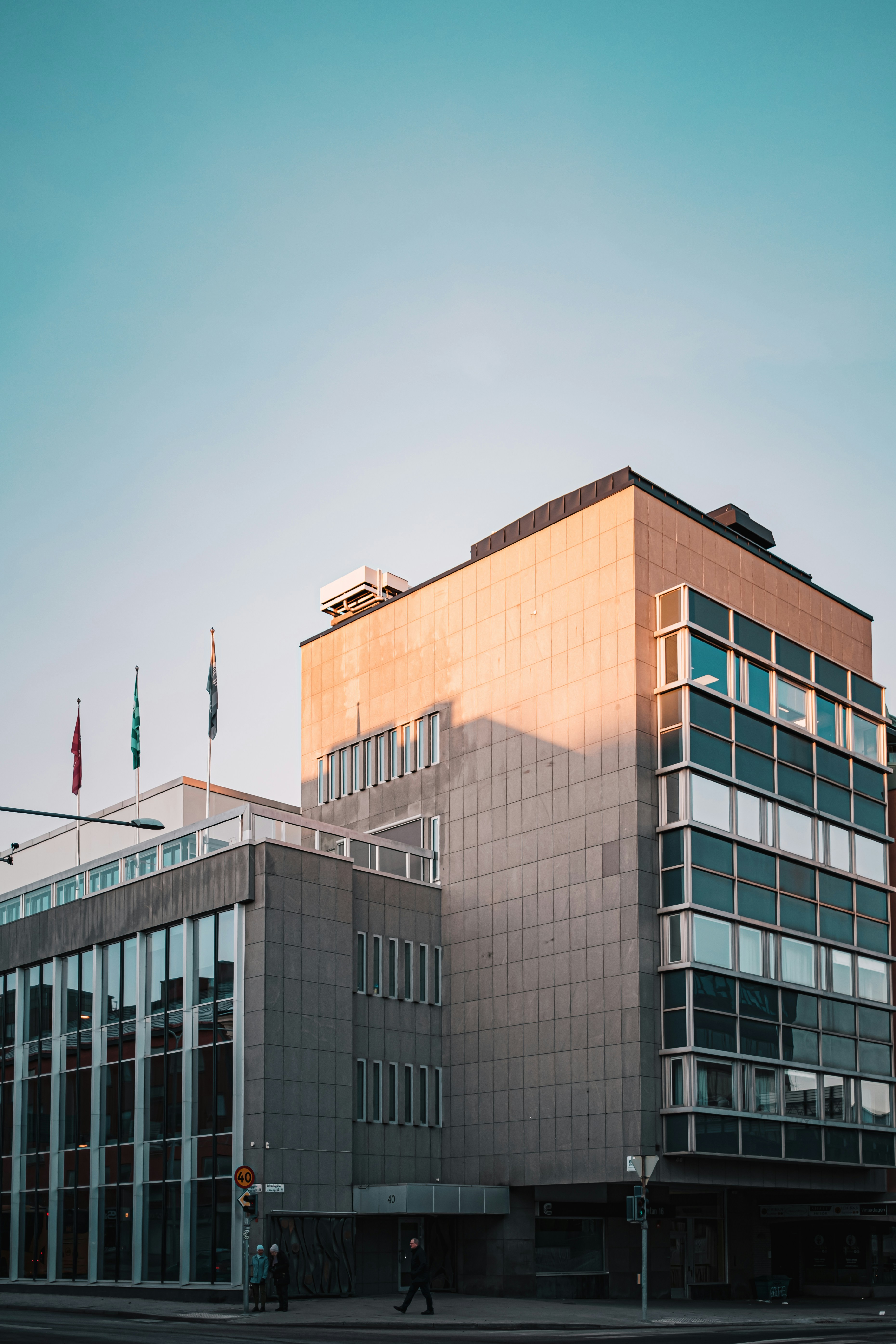Sunlight casts warm tones on a modern office building against a clear blue sky.