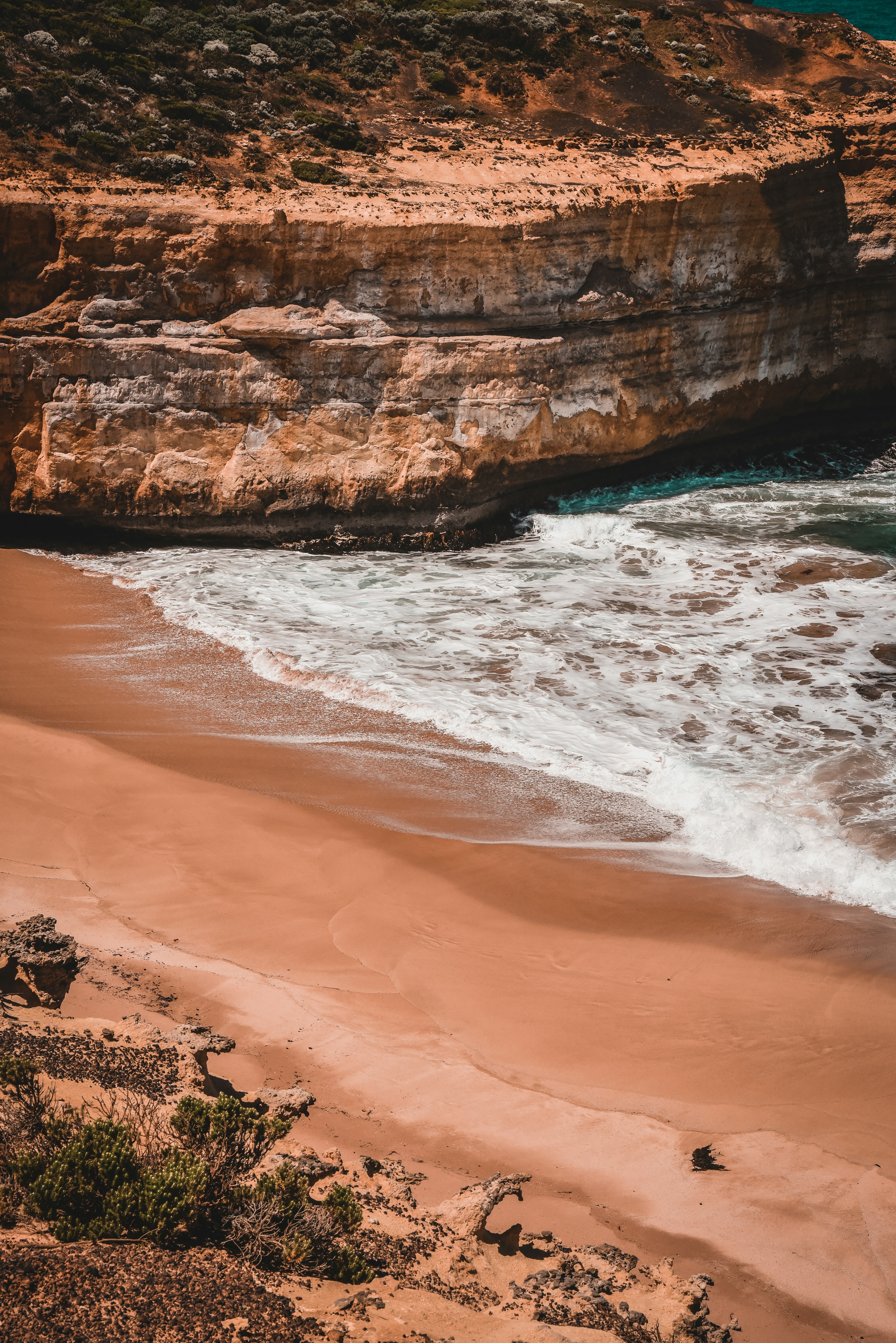Une plage de sable à côté d’une falaise rocheuse photo – Photo La ...