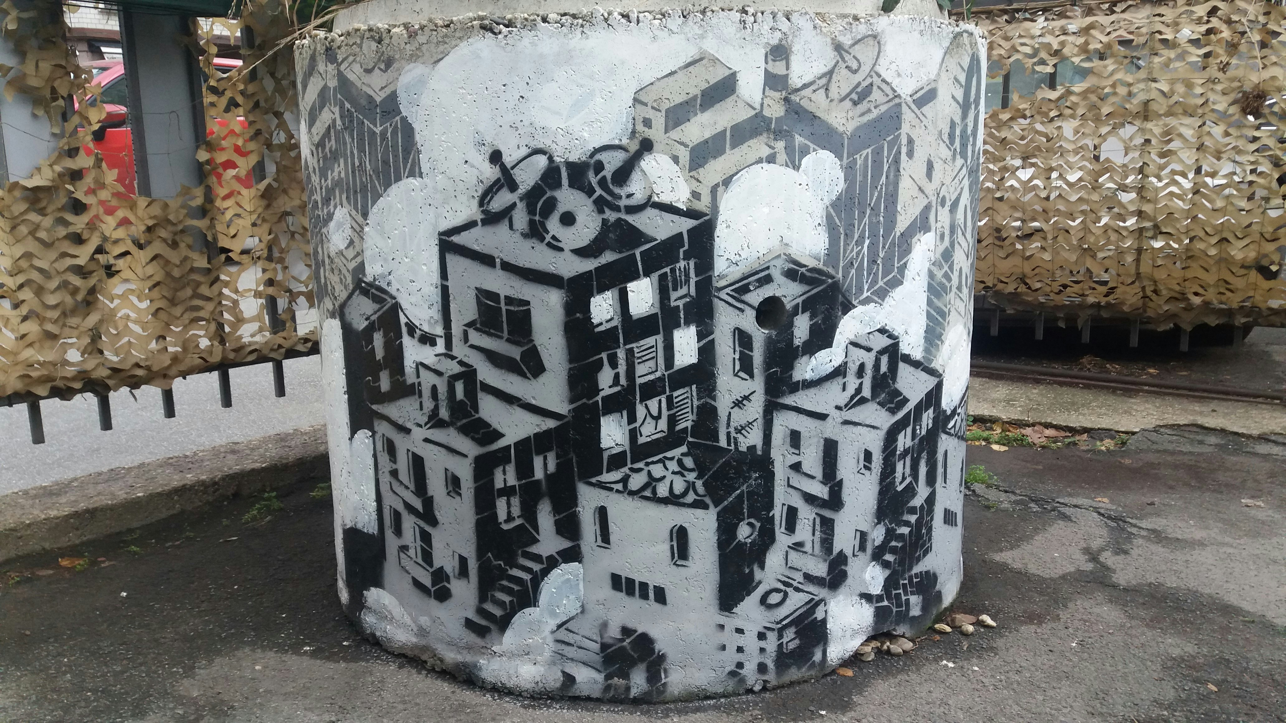 Urban mural on a cylindrical planter: monochrome cityscape