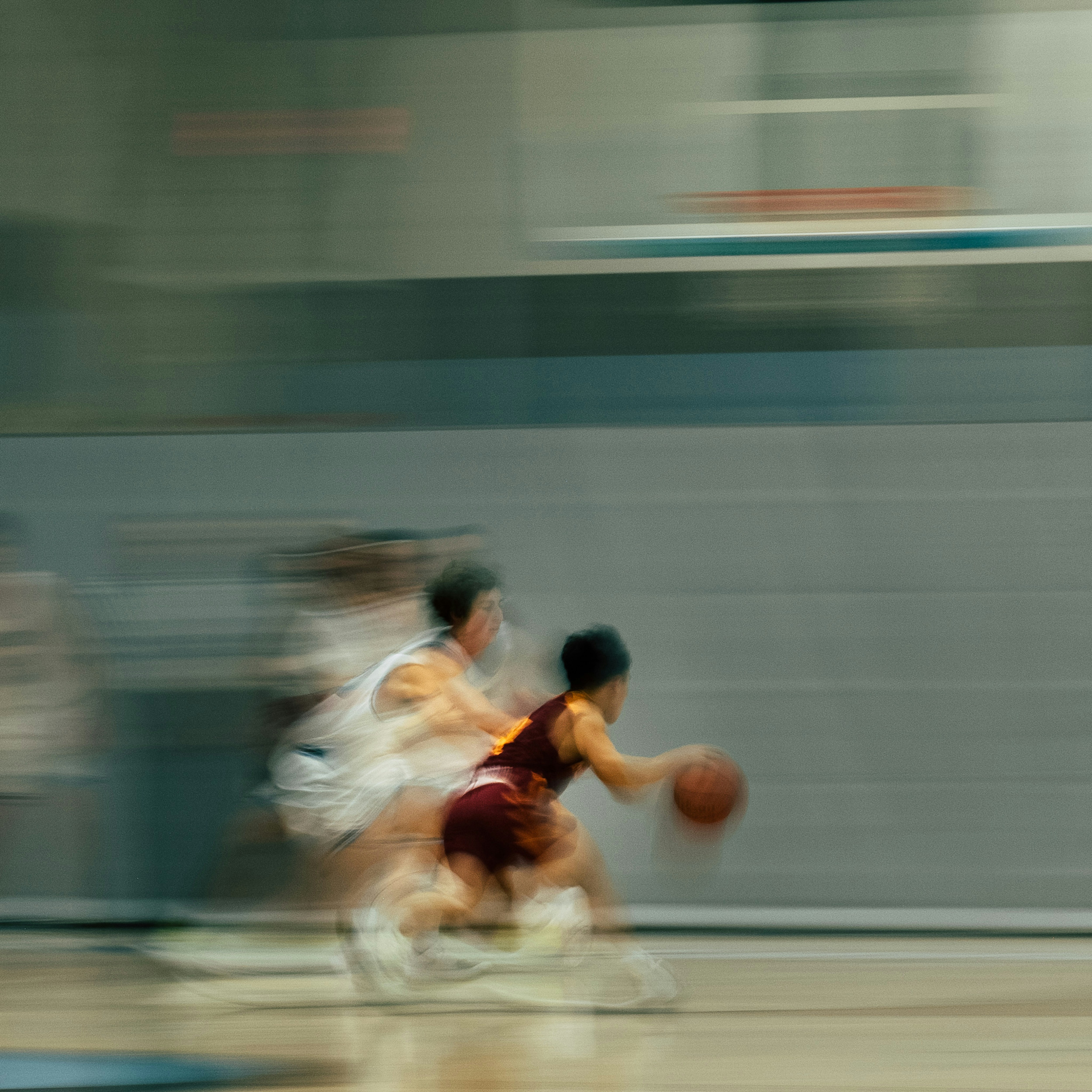Dynamic basketball scene with players in motion, showcasing agility and determination during a game.
