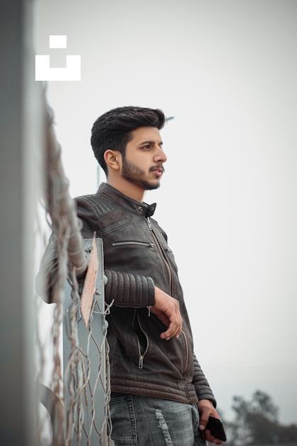 A Man Standing Next To A Chain Link Fence Photo Free People Image On