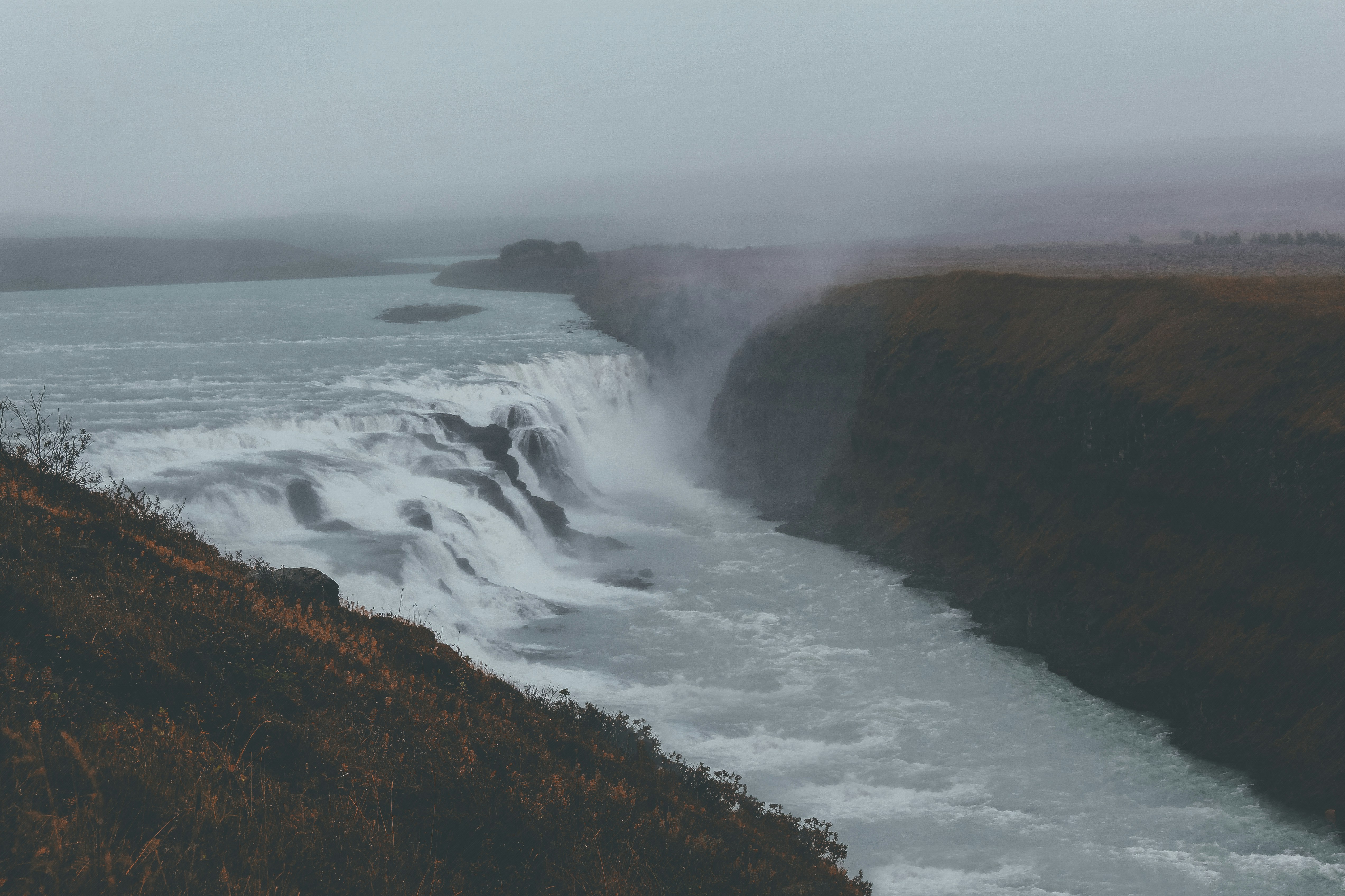 Mist Veil Over a Broad Cascade in a Wind-Swept Gorge
