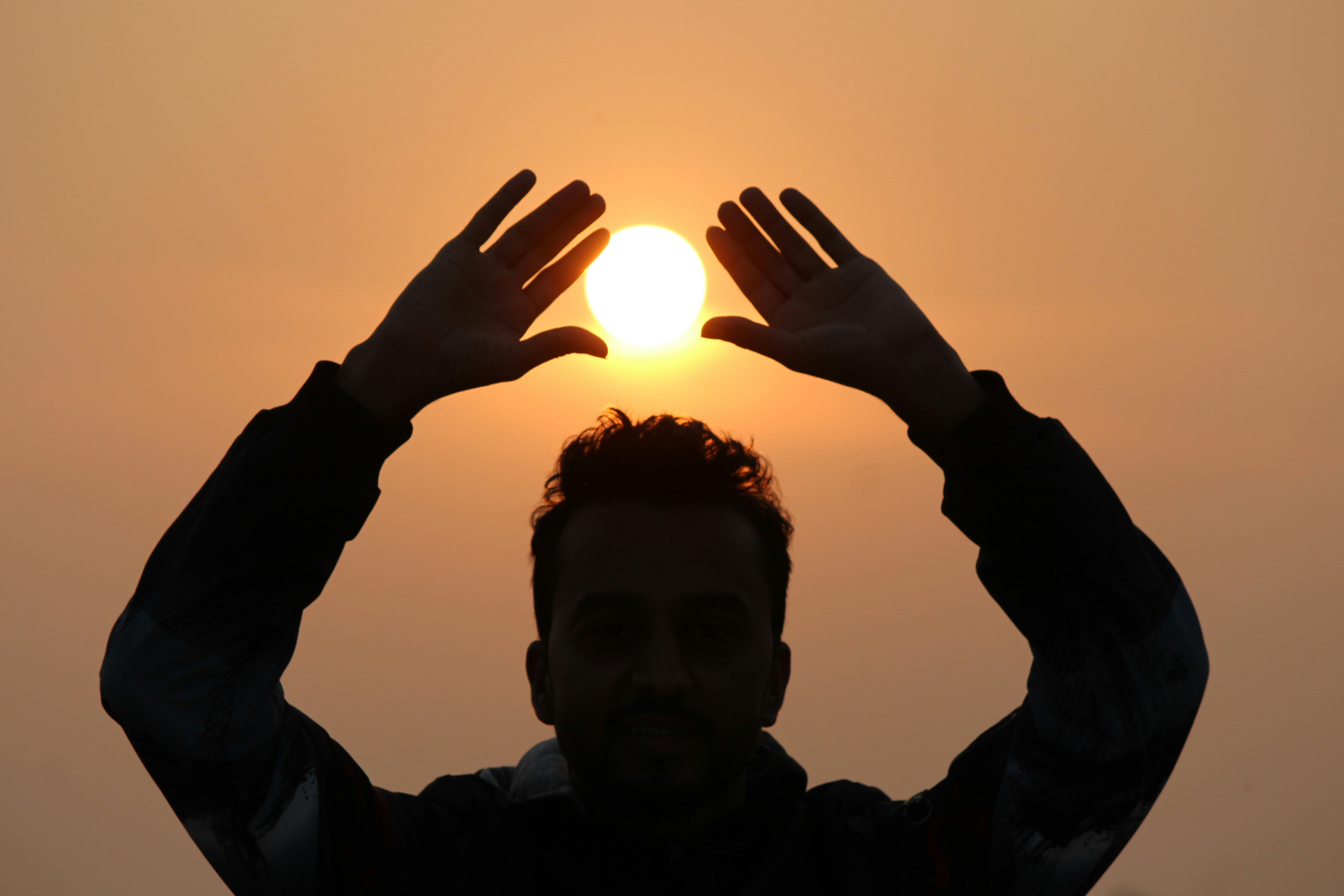 A man holding his hands up to the sun photo – Free Sun in hand Image on ...