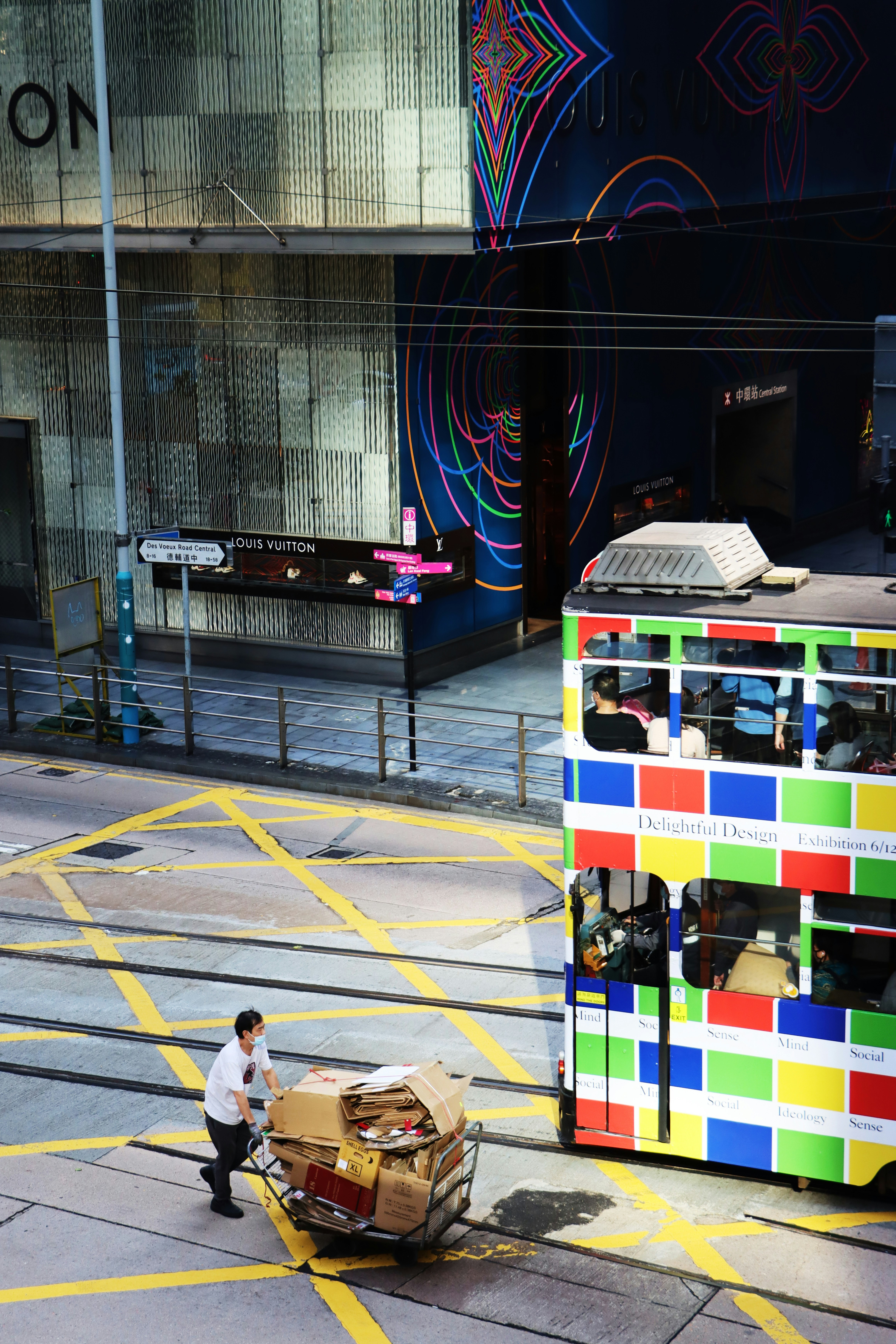 A man pushing a cart with a double decker bus photo – Free Central ...