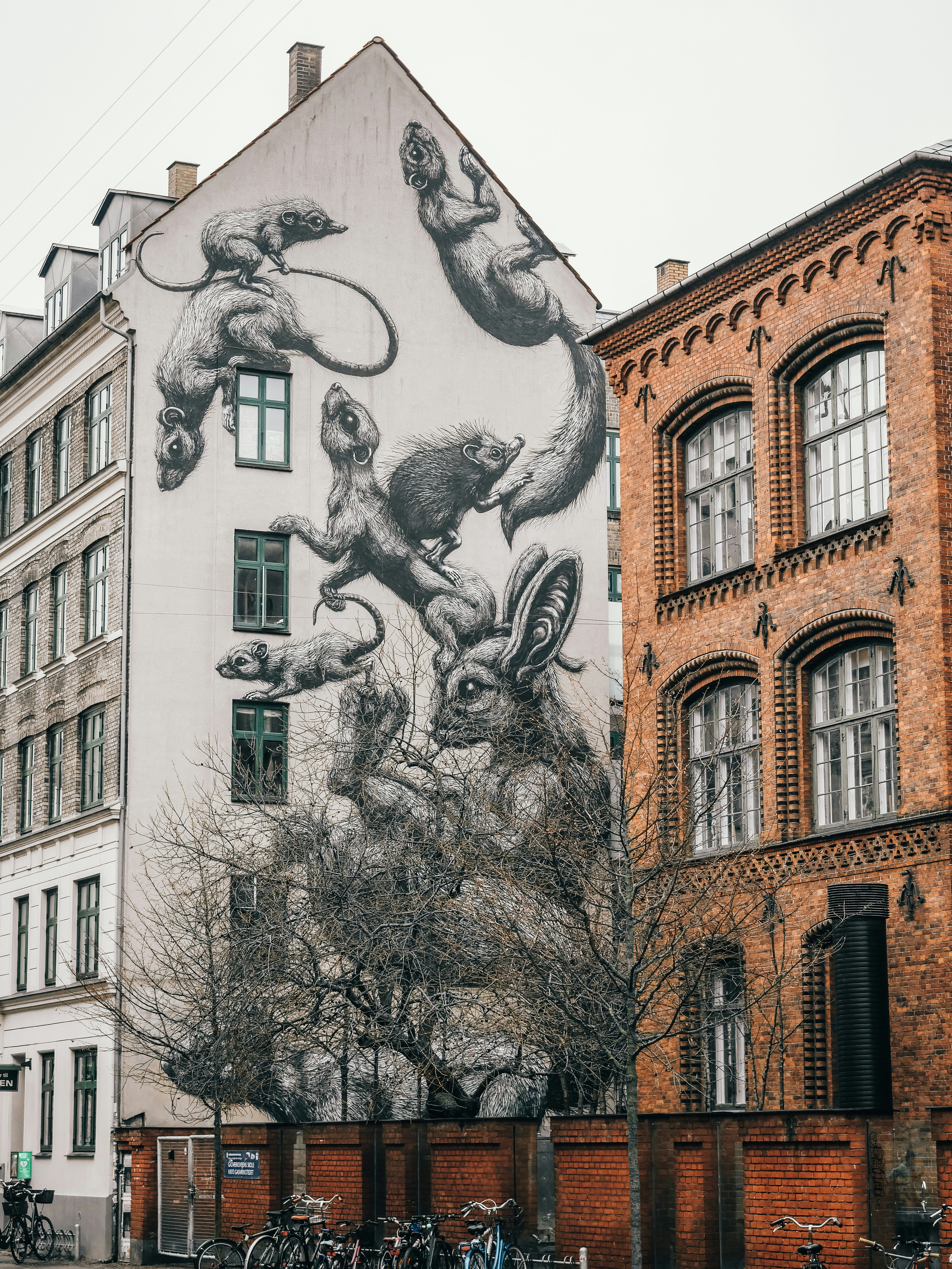 Whimsical Wall: A Pack of Mice and a Rabbit Conquer a Facade