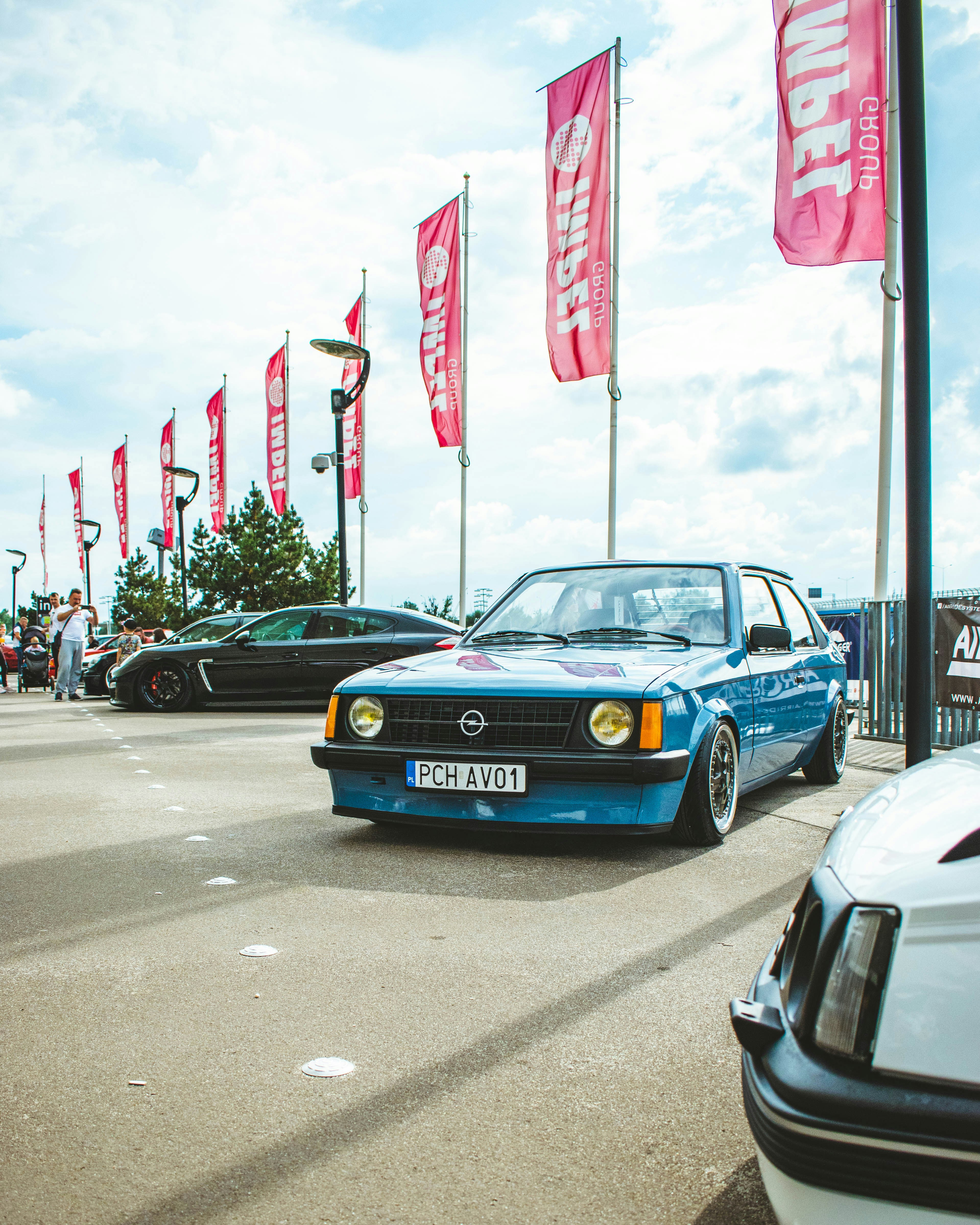 Blue Kadett in a Chrome Parade at a Sunlit Car Meet