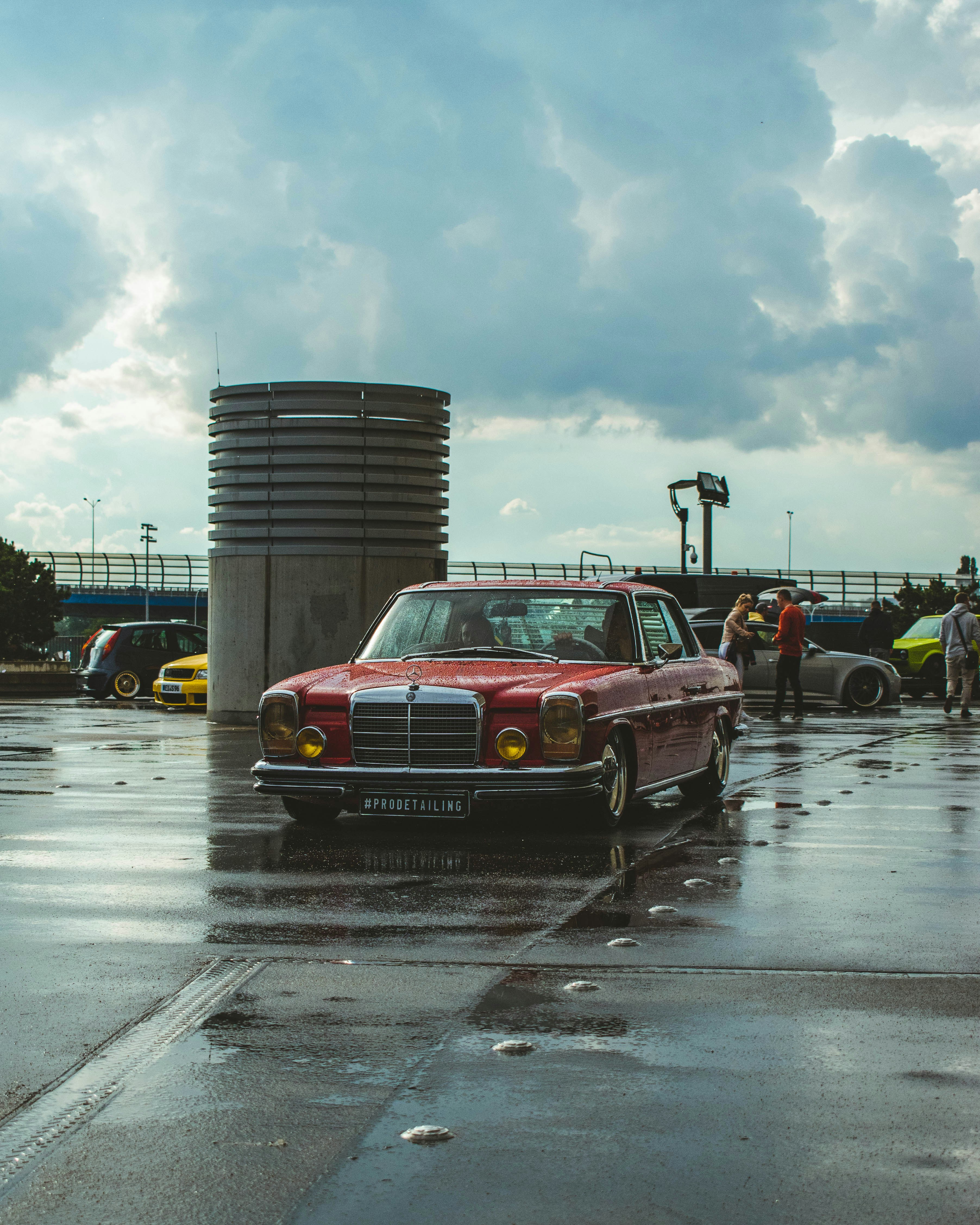 A red car parked on a wet parking lot photo – Free Vehicle Image on ...