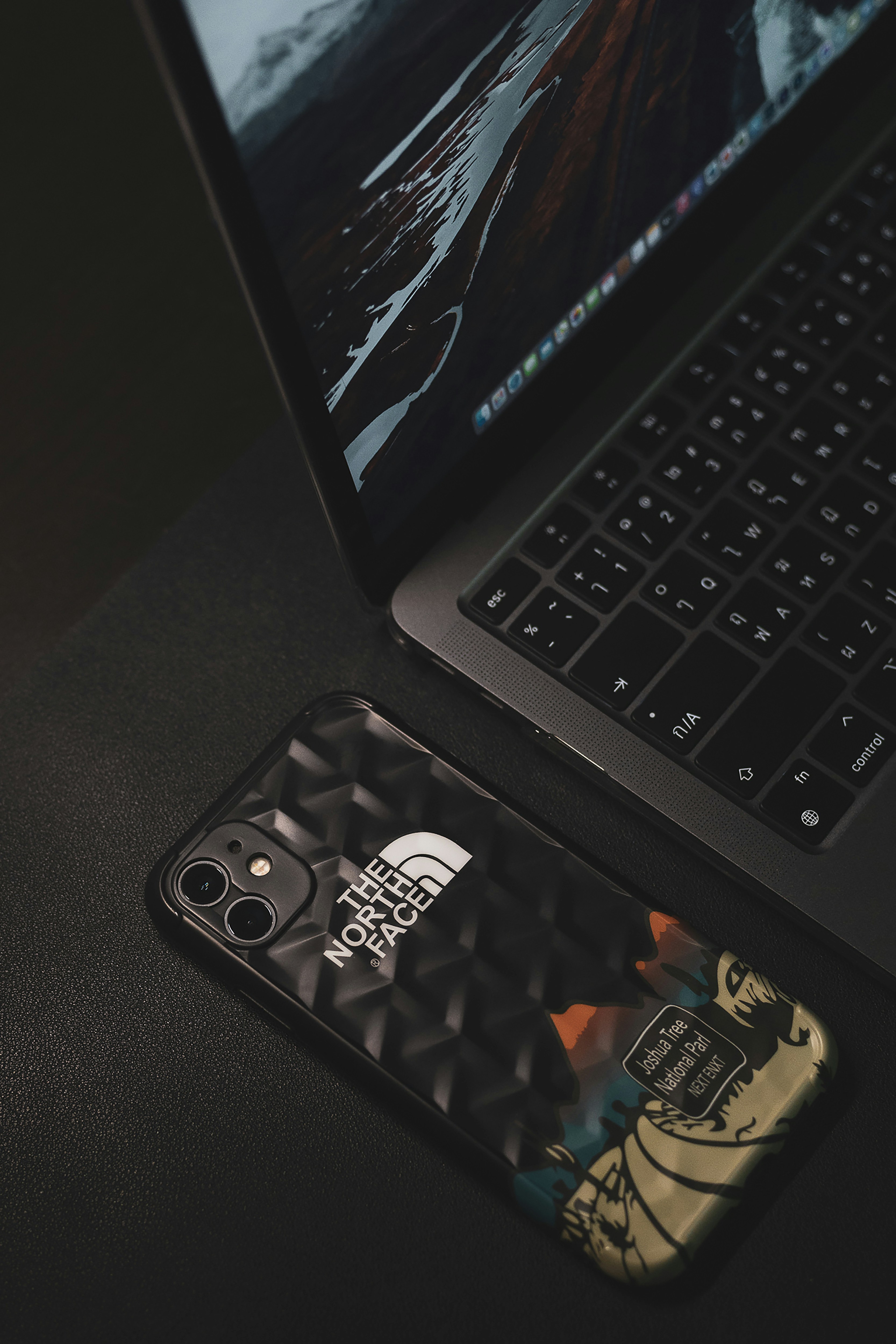 A laptop computer sitting on top of a desk next to a phone photo – Free ...