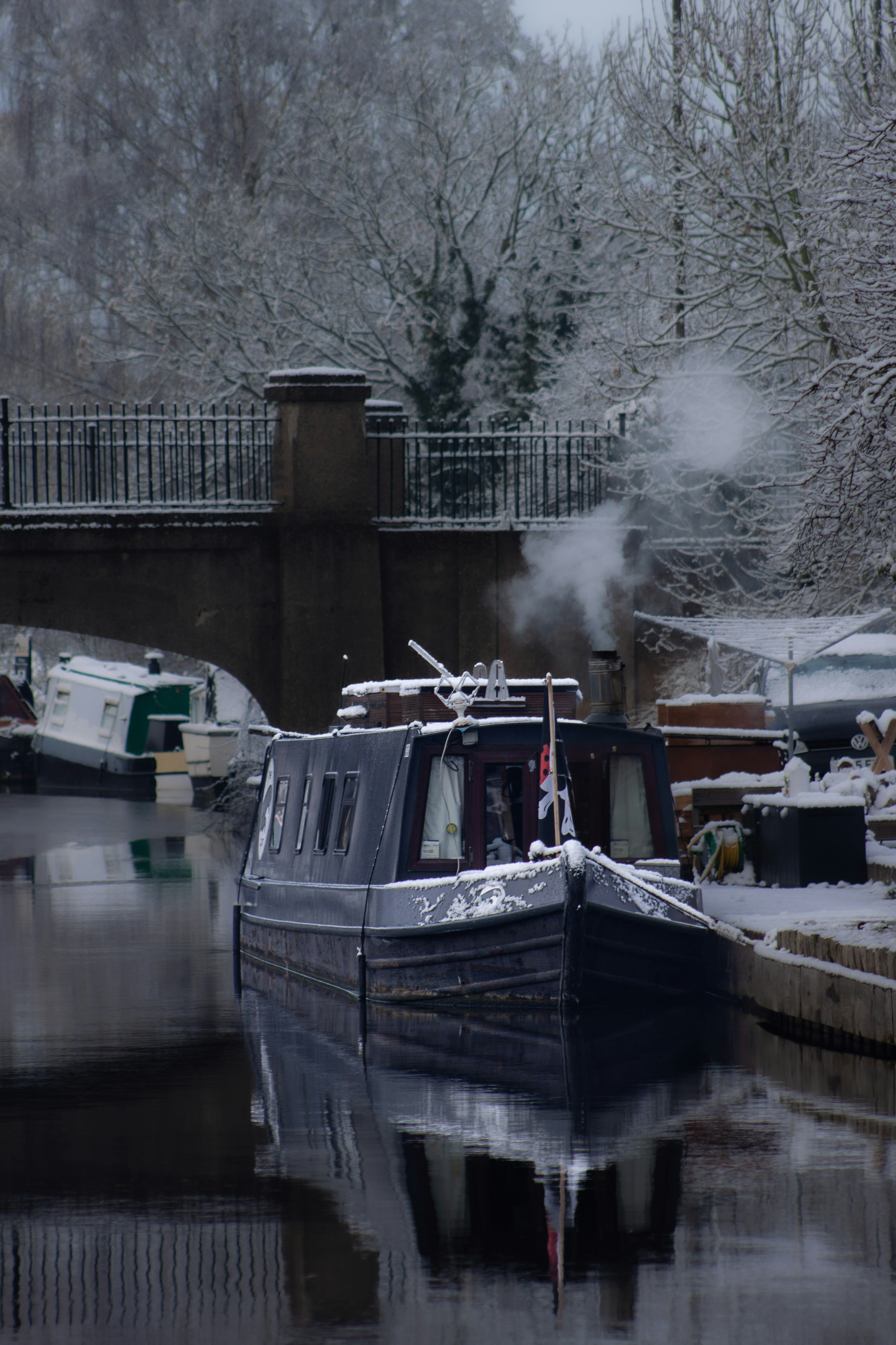 Winter Mooring: Steam, Snow, and Reflections Under a Bridge