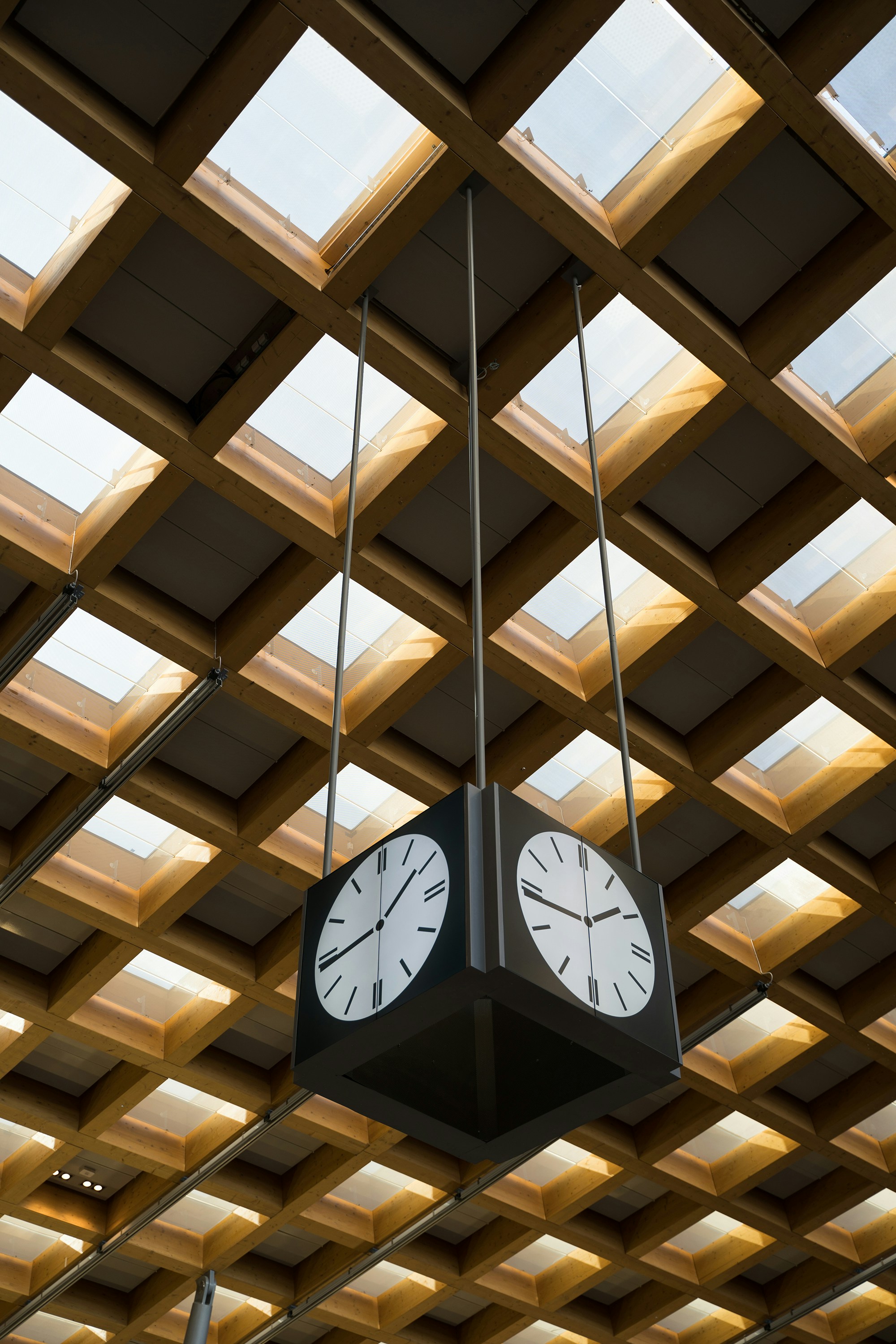 a clock hanging from the ceiling of a building
