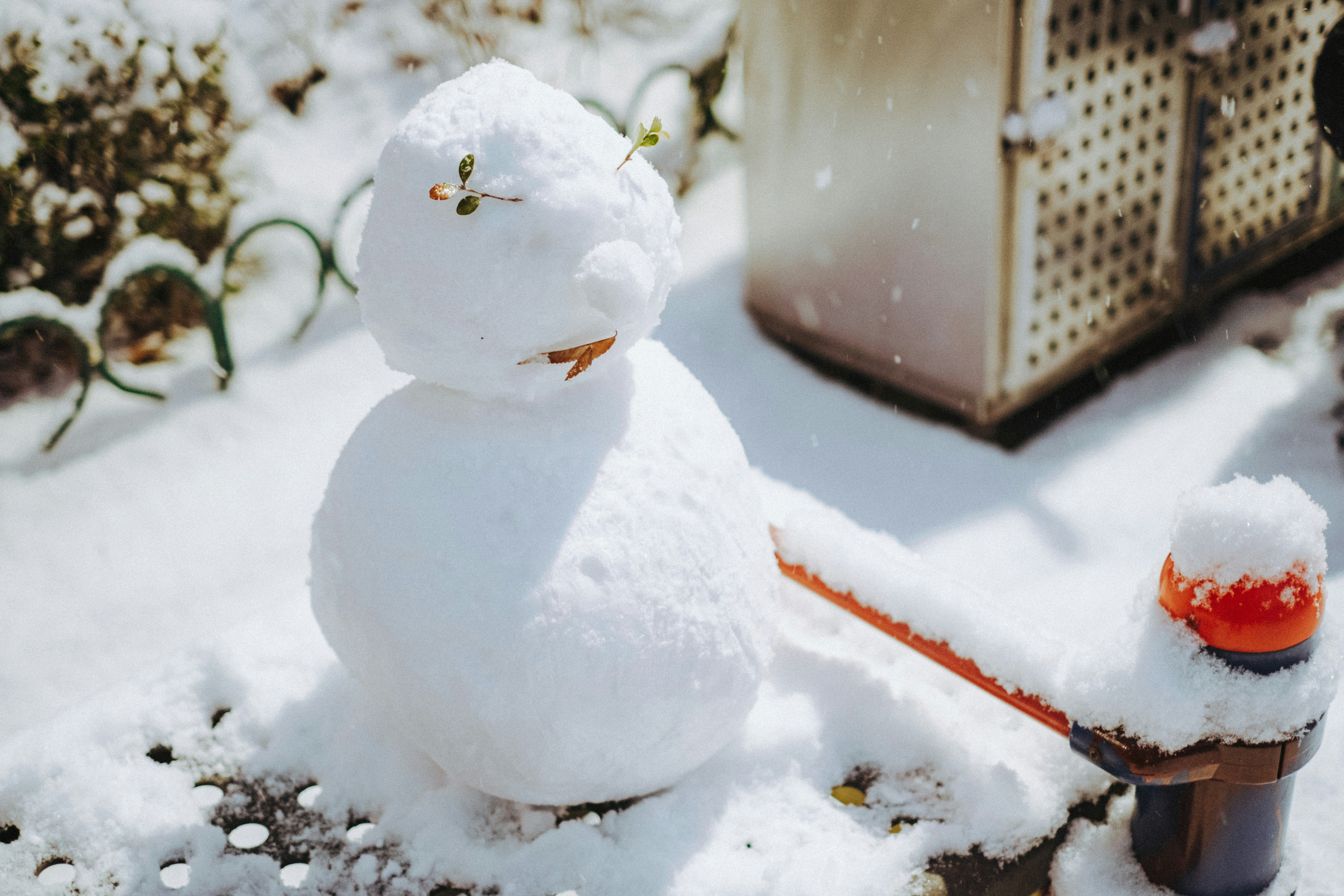 Tiny Snowman on a Snow-Blanketed Surface with a Lantern in Quiet Winter Light
