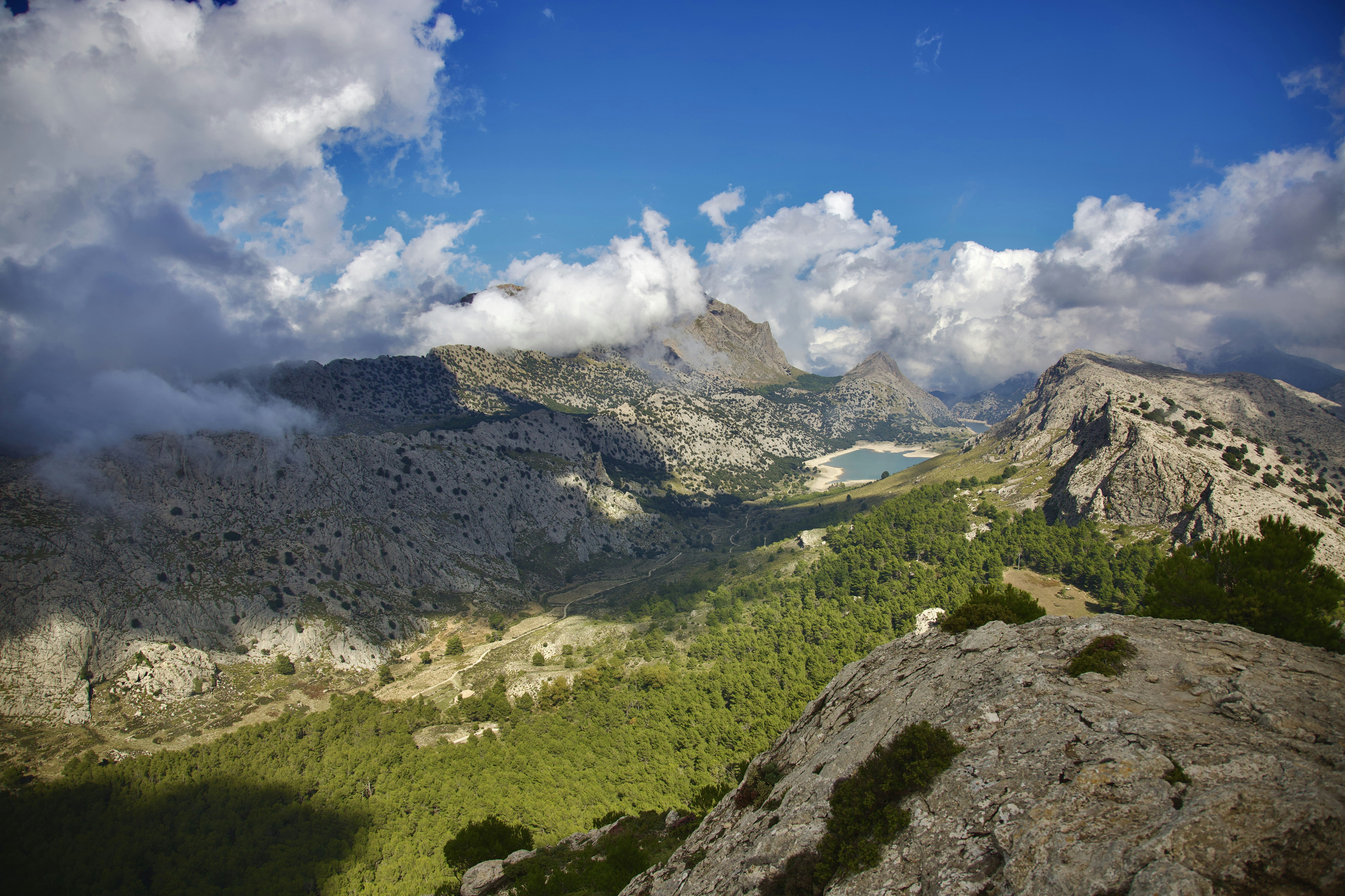 Azure Summit: A Panoramic View of Alpine Crags and Lakelet