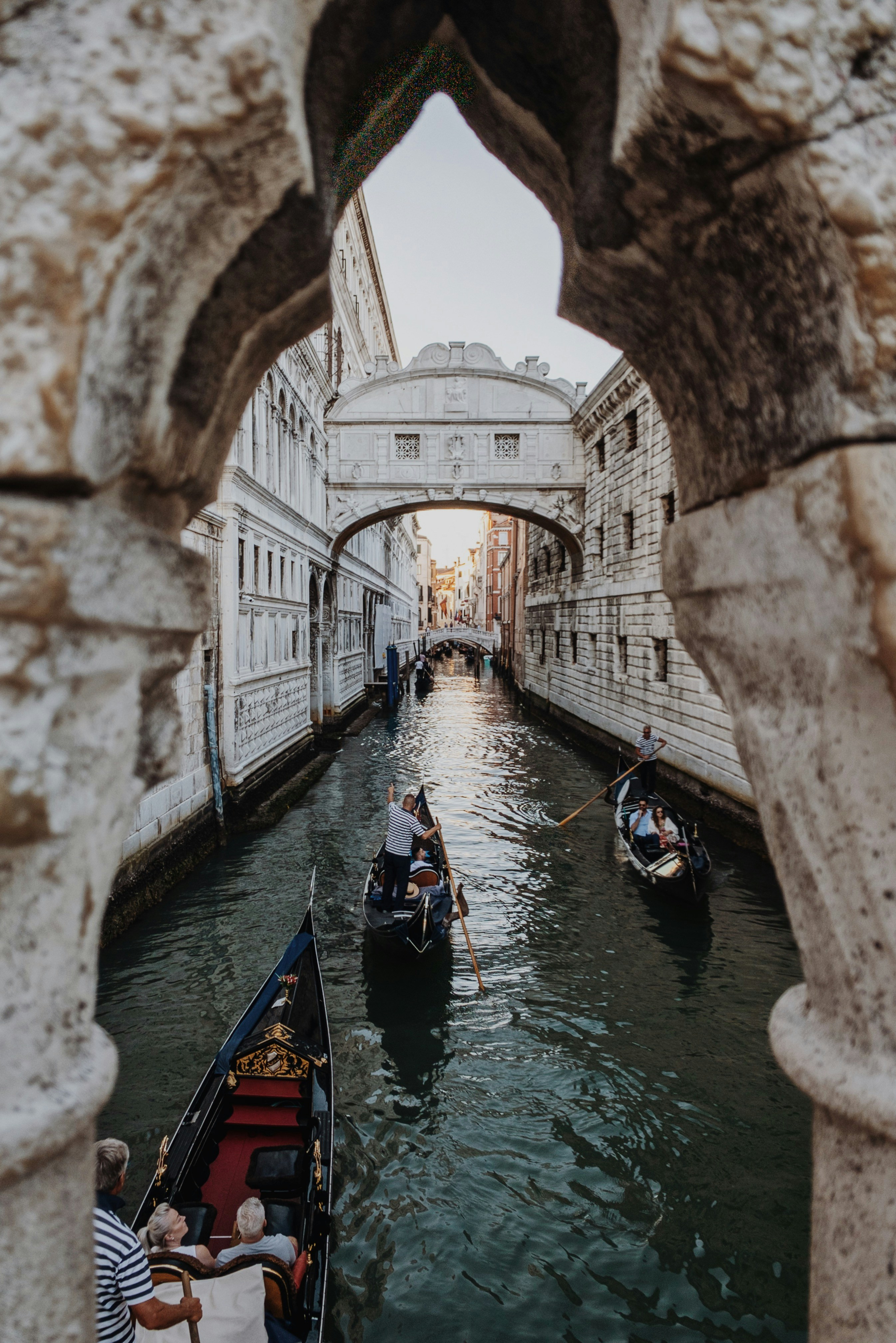 Sunlight Through the Arch: Gondolas Thread the Venetian Channel