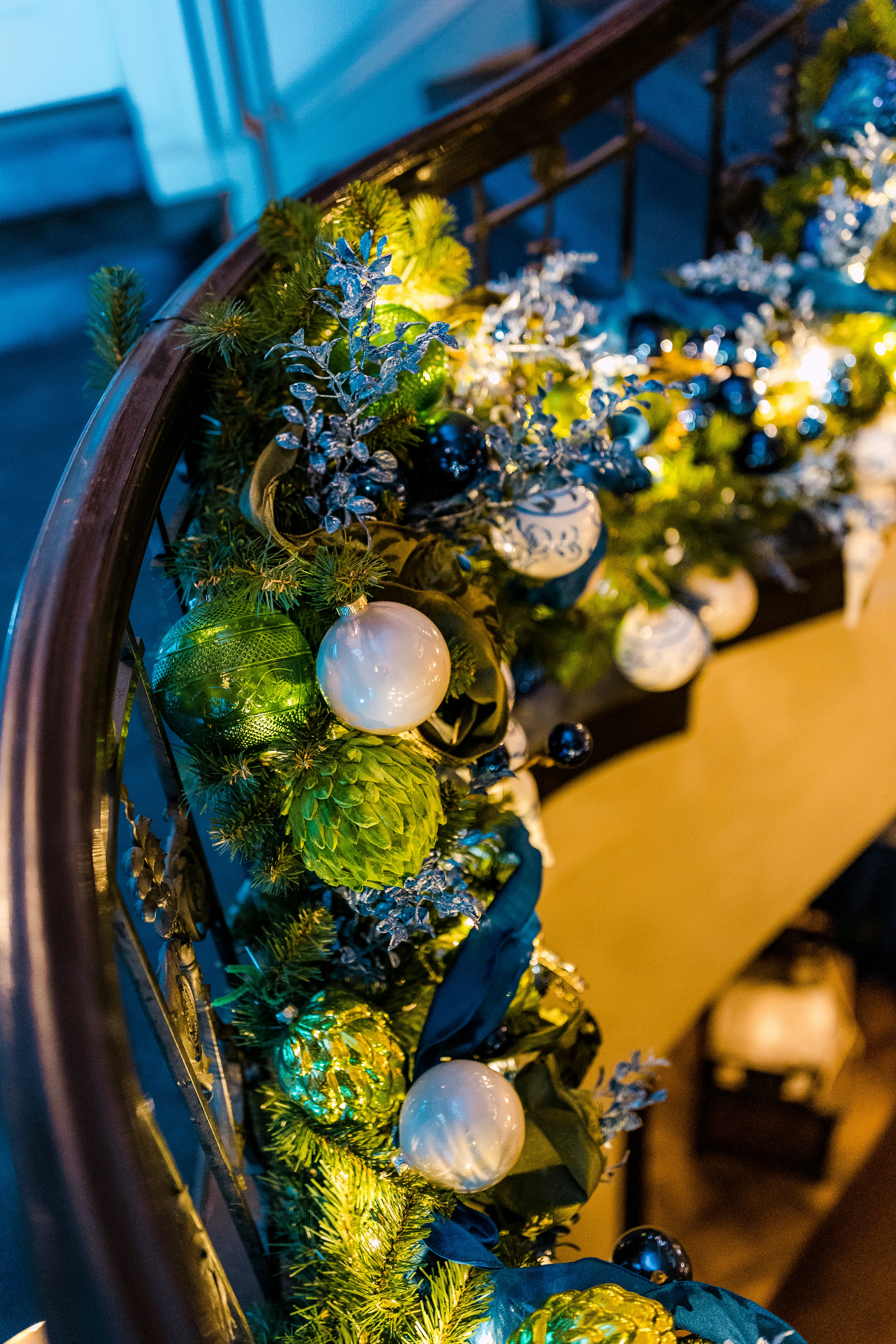 a staircase decorated with christmas ornaments and greenery